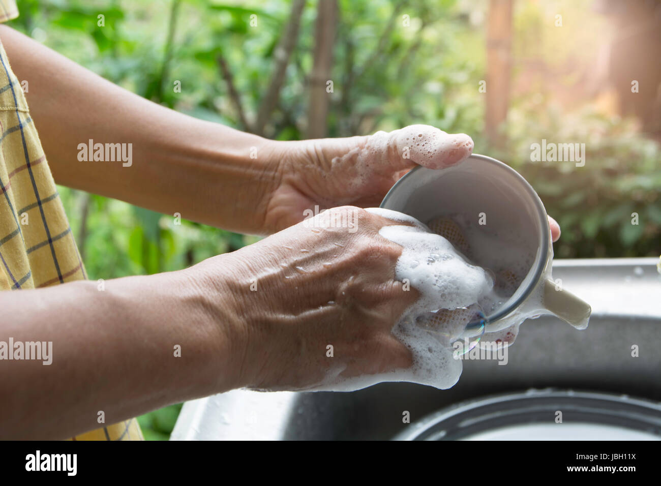 Woman washing utensil in hi-res stock photography and images - Alamy