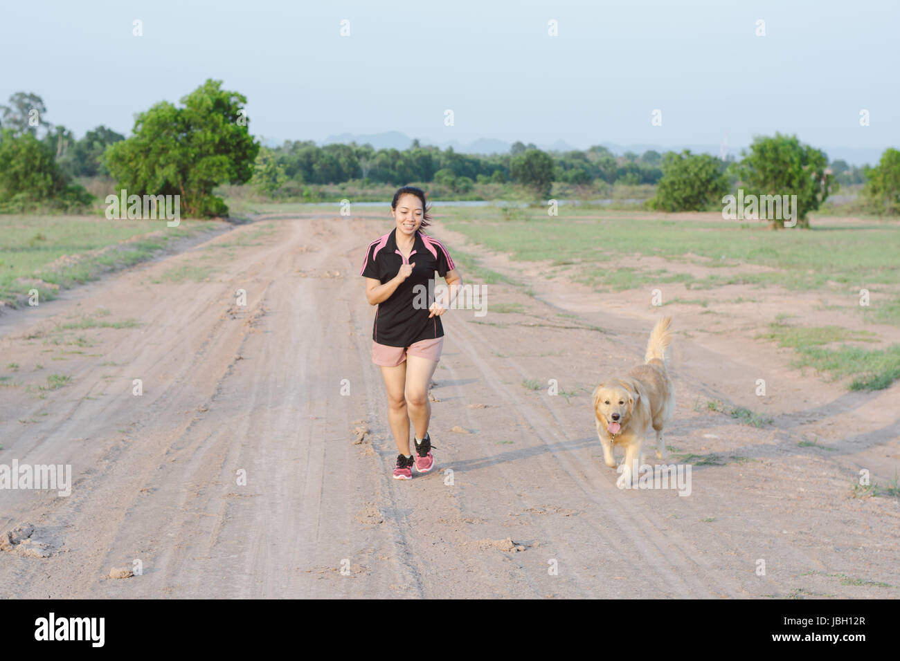 Happy young woman jogging with her beagle dog Stock Photo - Alamy