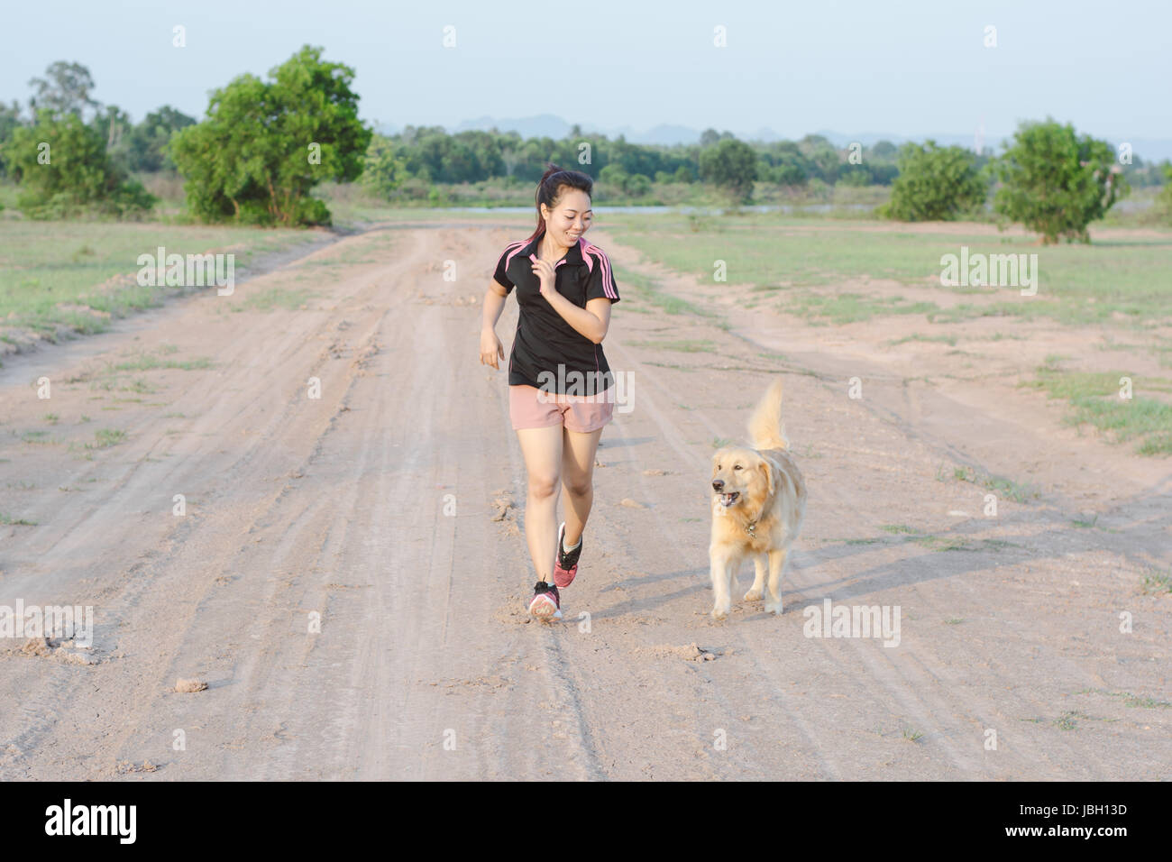 Happy young woman jogging with her beagle dog Stock Photo - Alamy