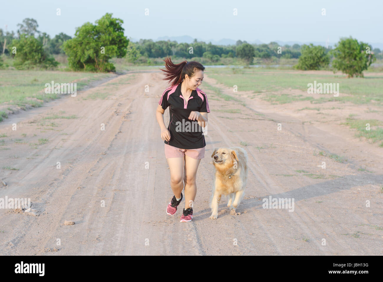 Happy young woman jogging with her beagle dog Stock Photo - Alamy