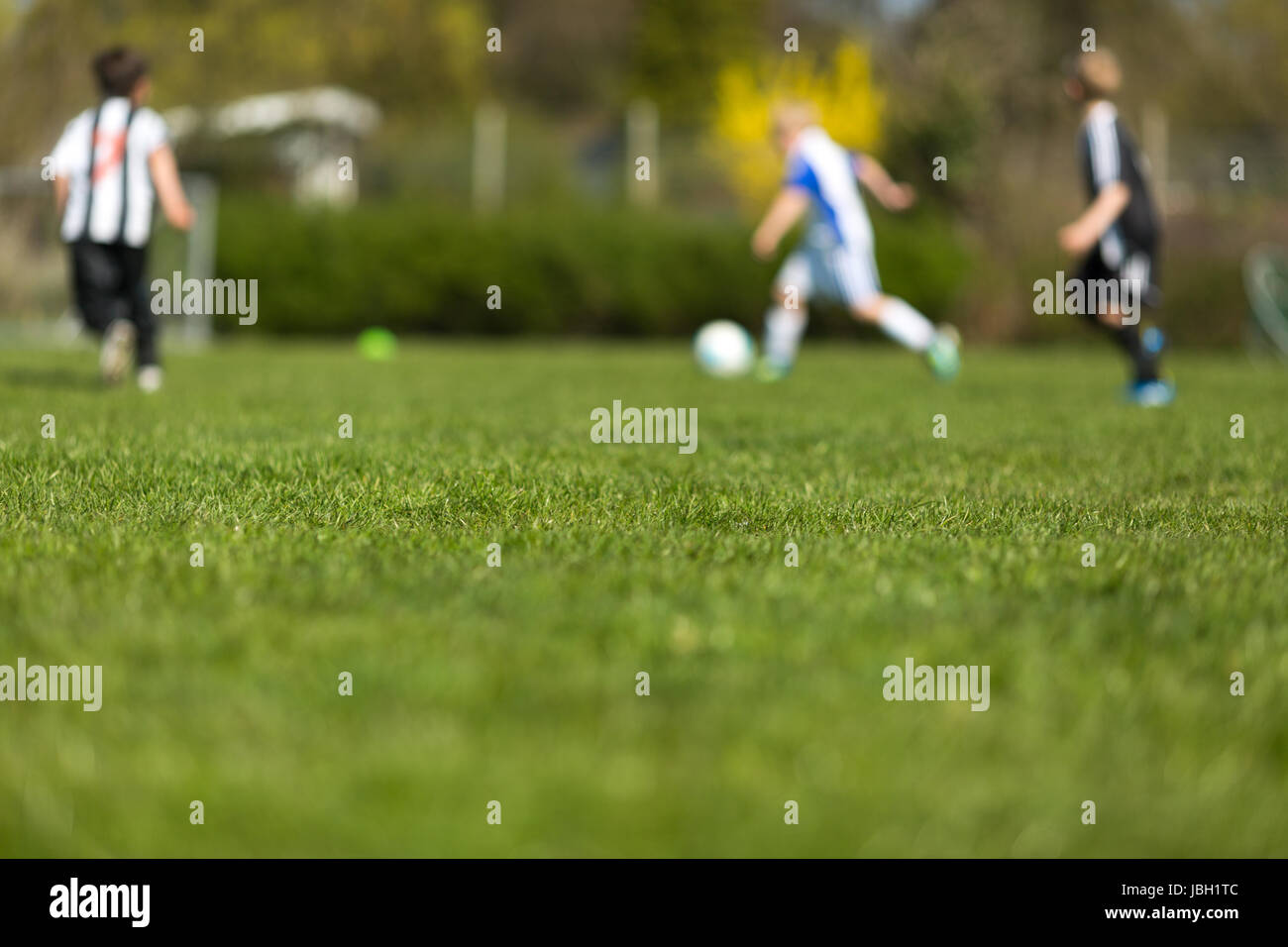 Three blurred young soccer players during a soccer match Stock Photo ...