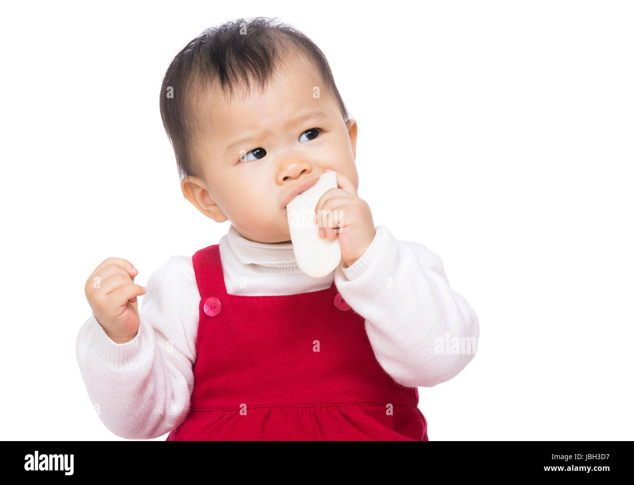 Asian baby girl eating biscuit Stock Photo - Alamy