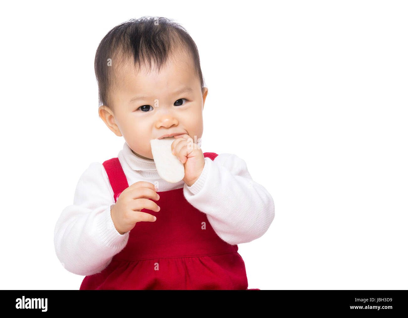 Asian baby girl eating biscuit Stock Photo - Alamy