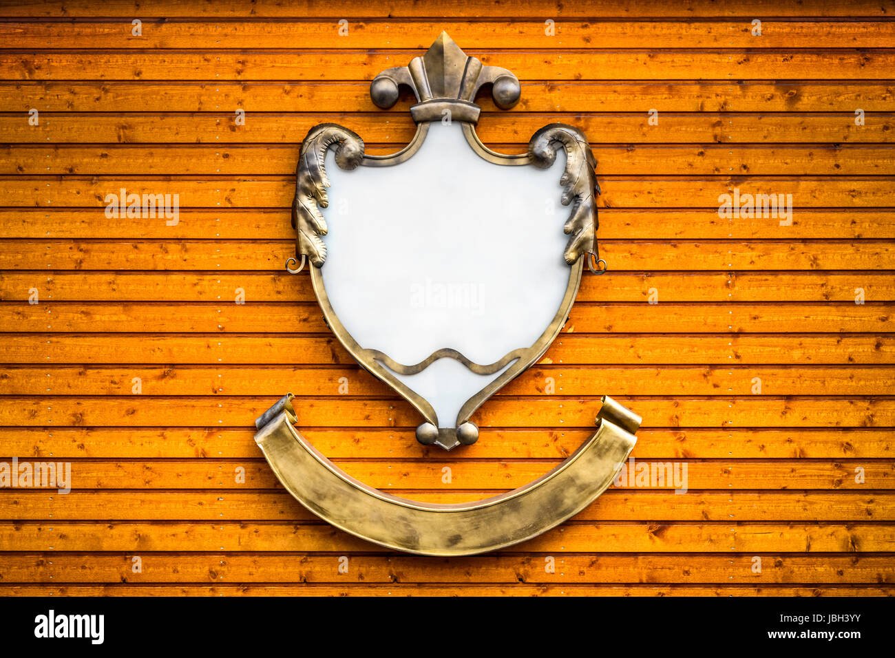 Emblem with frame from metal and white background on wooden wall Stock ...