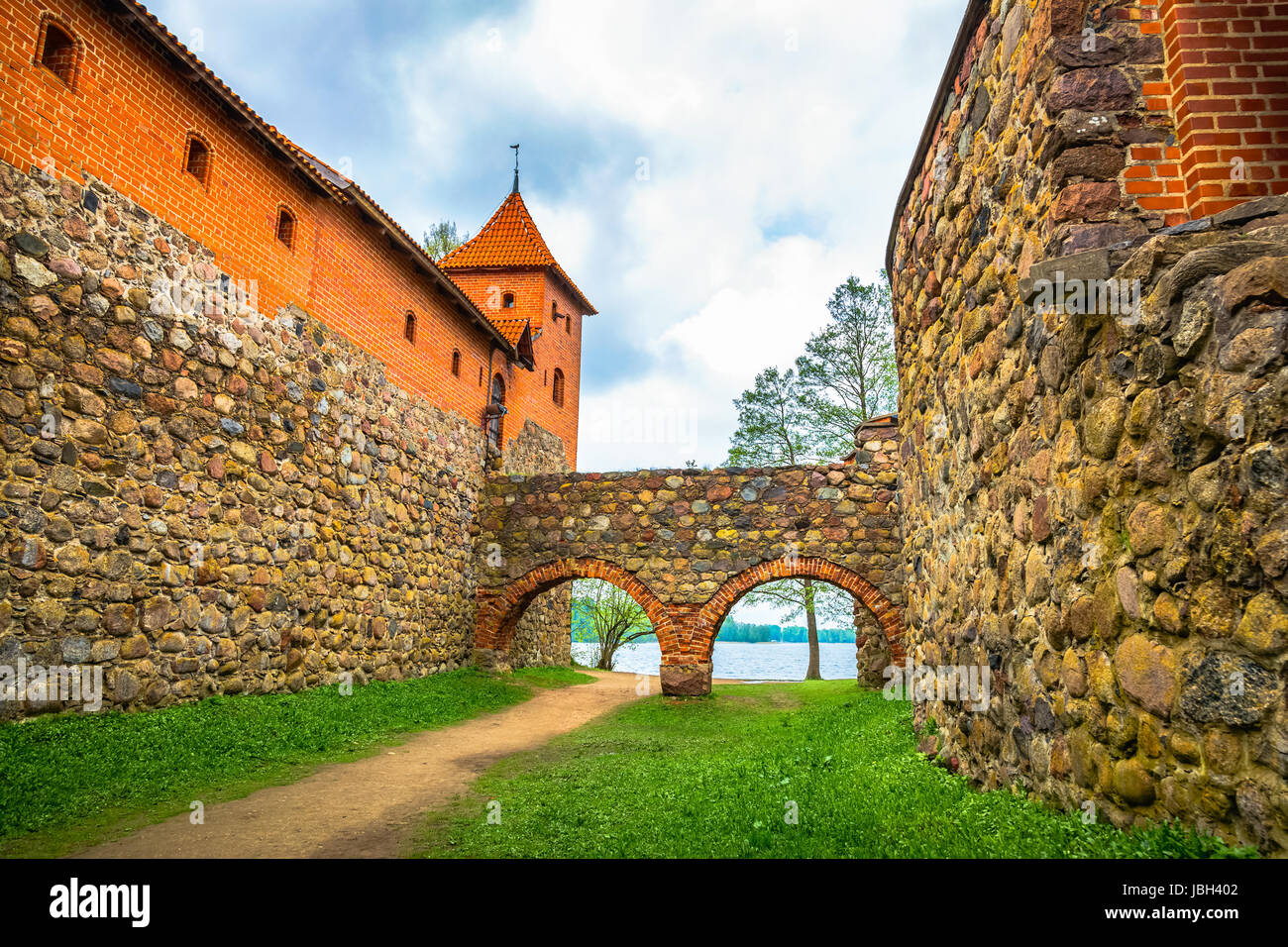 View from inside of castle on stone walls, archs and red bricks tower ...