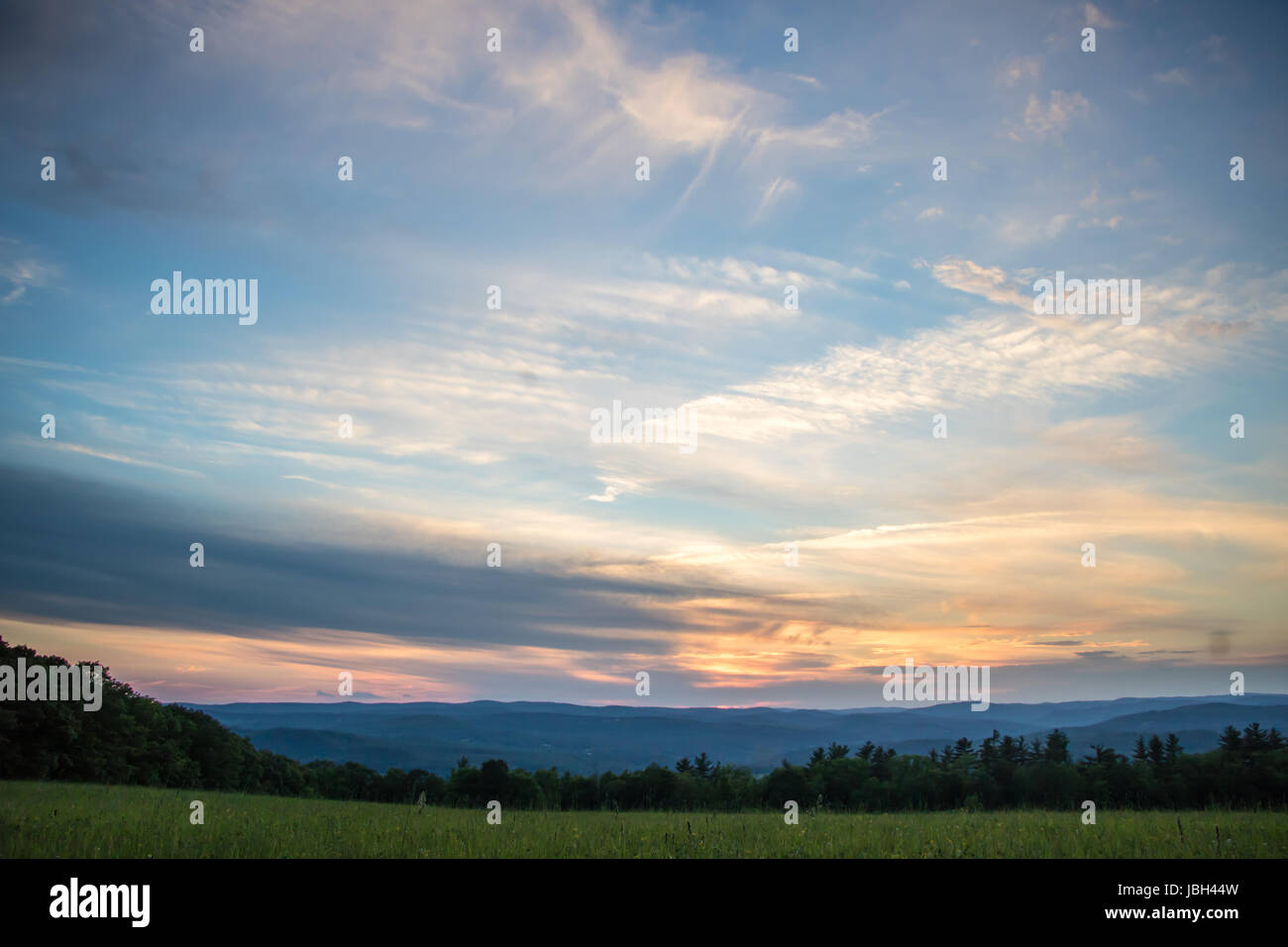 Beautiful Sunset over Meadow with Mountain View Stock Photo - Alamy