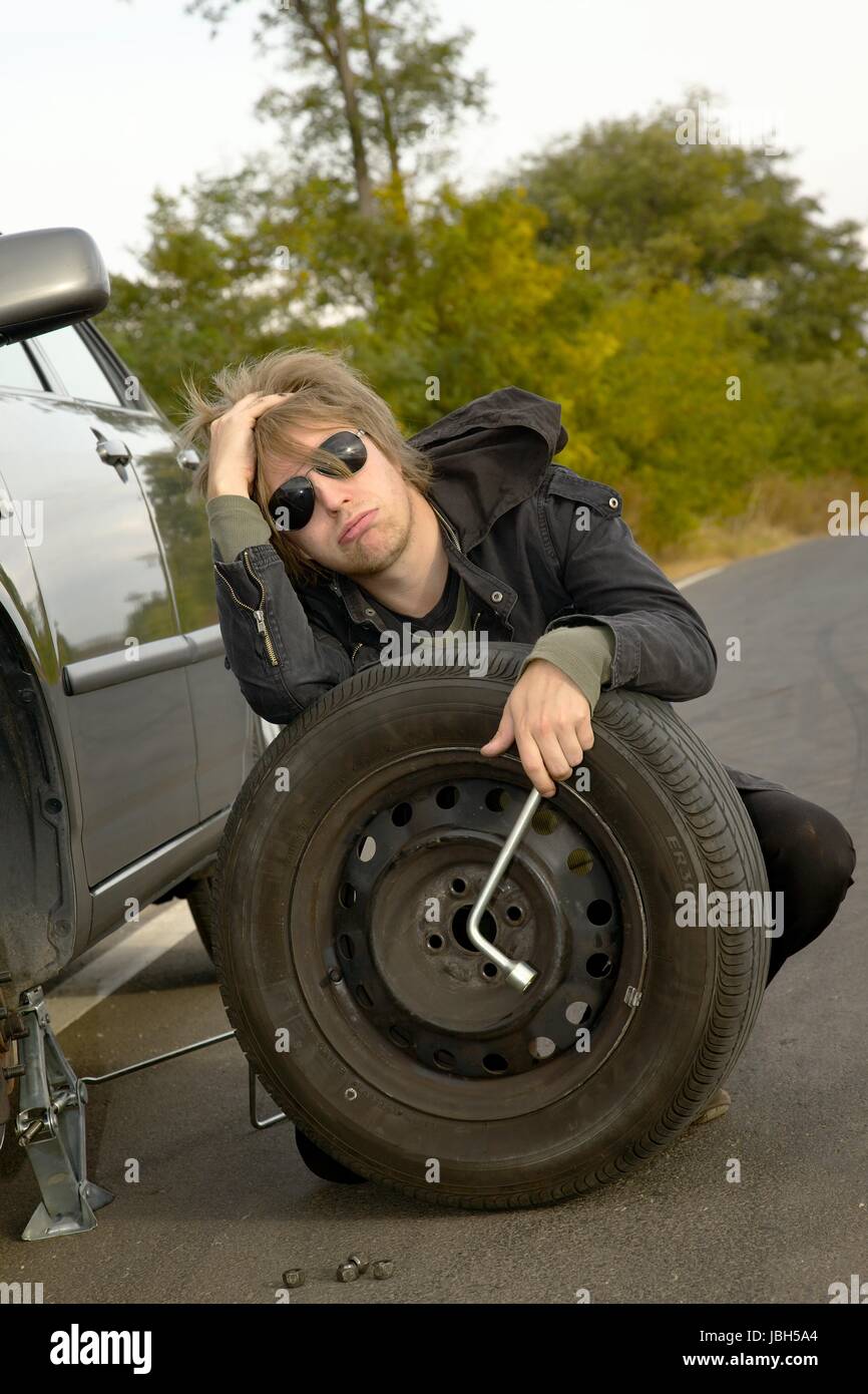 Man with wheel on the road Stock Photo - Alamy