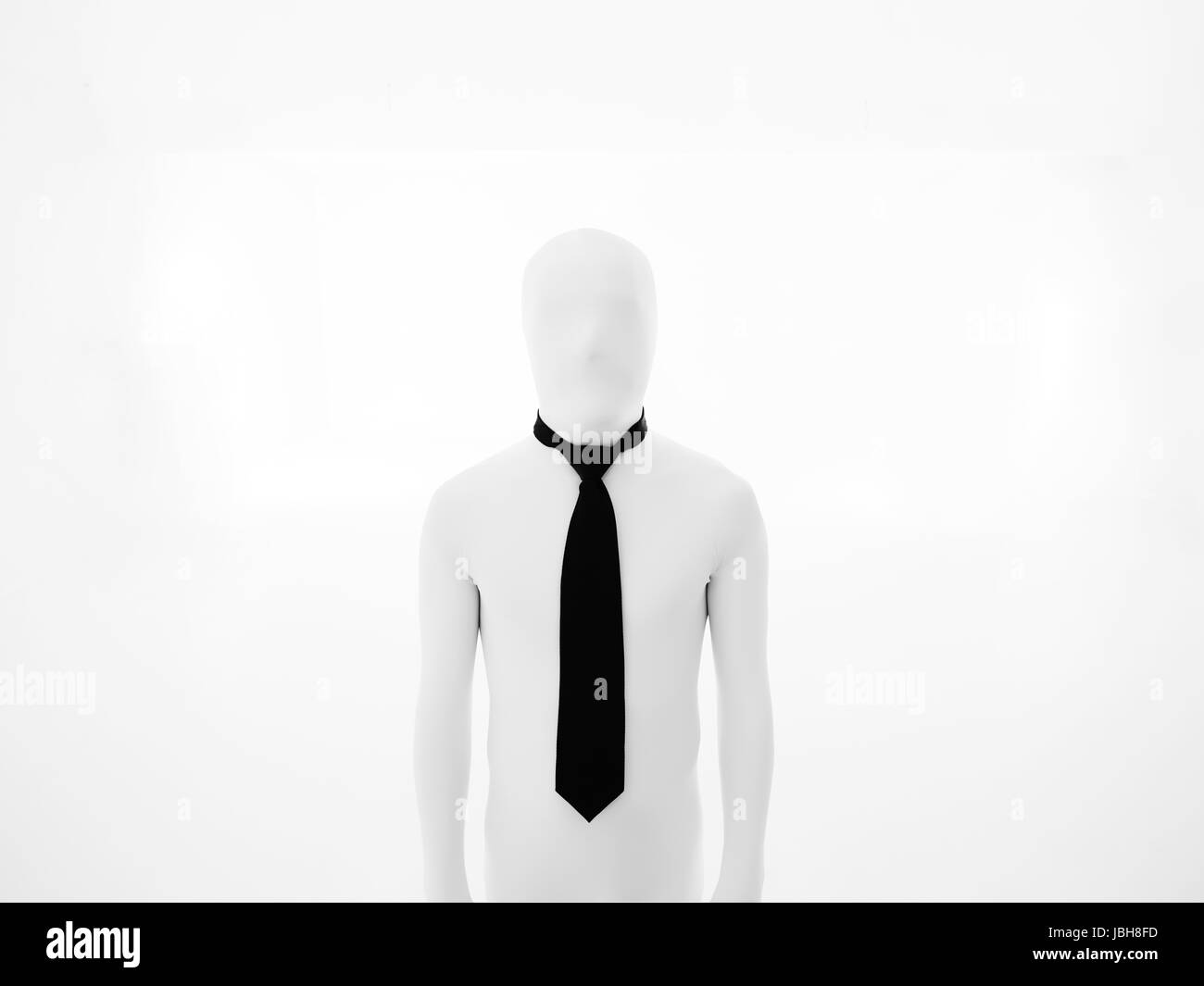 faceless white businessman standing straight, wearing a black tie, on ...