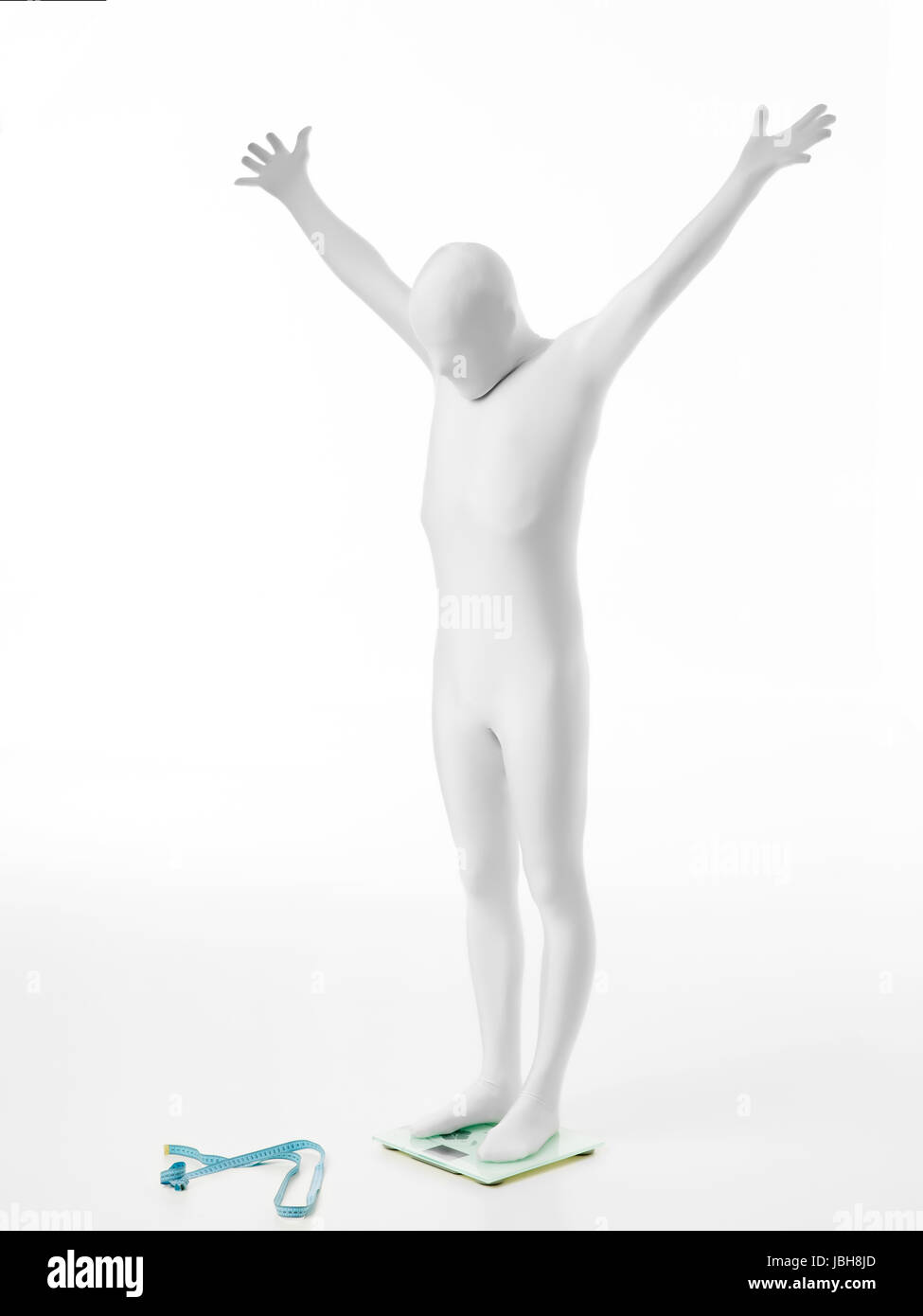 Faceless man dressed in white is measured on a scale seems happy ...