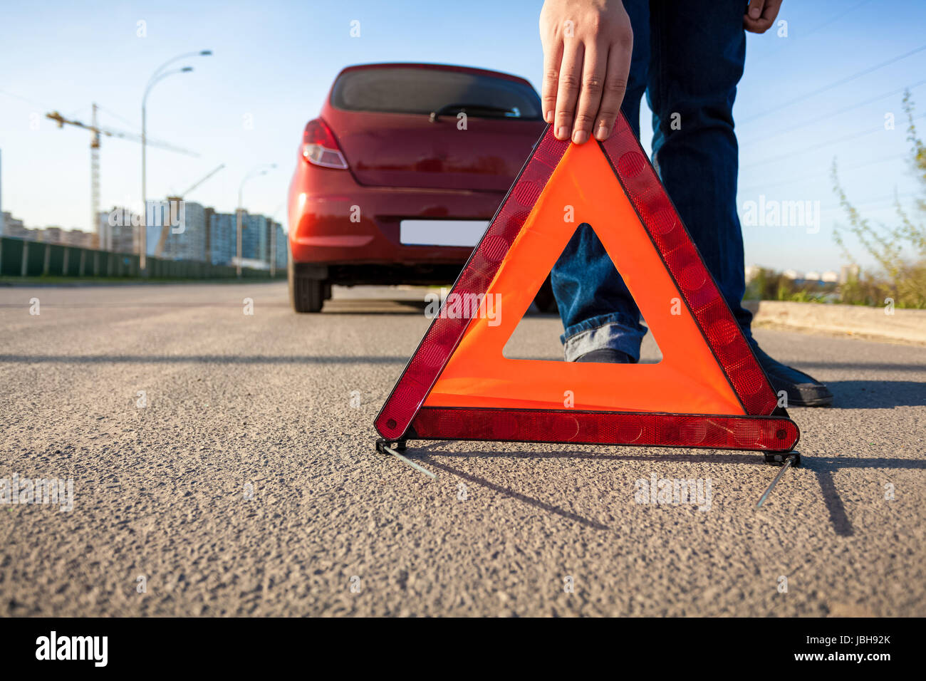 Closeup photo of man putting triangle warning sign on road Stock Photo ...
