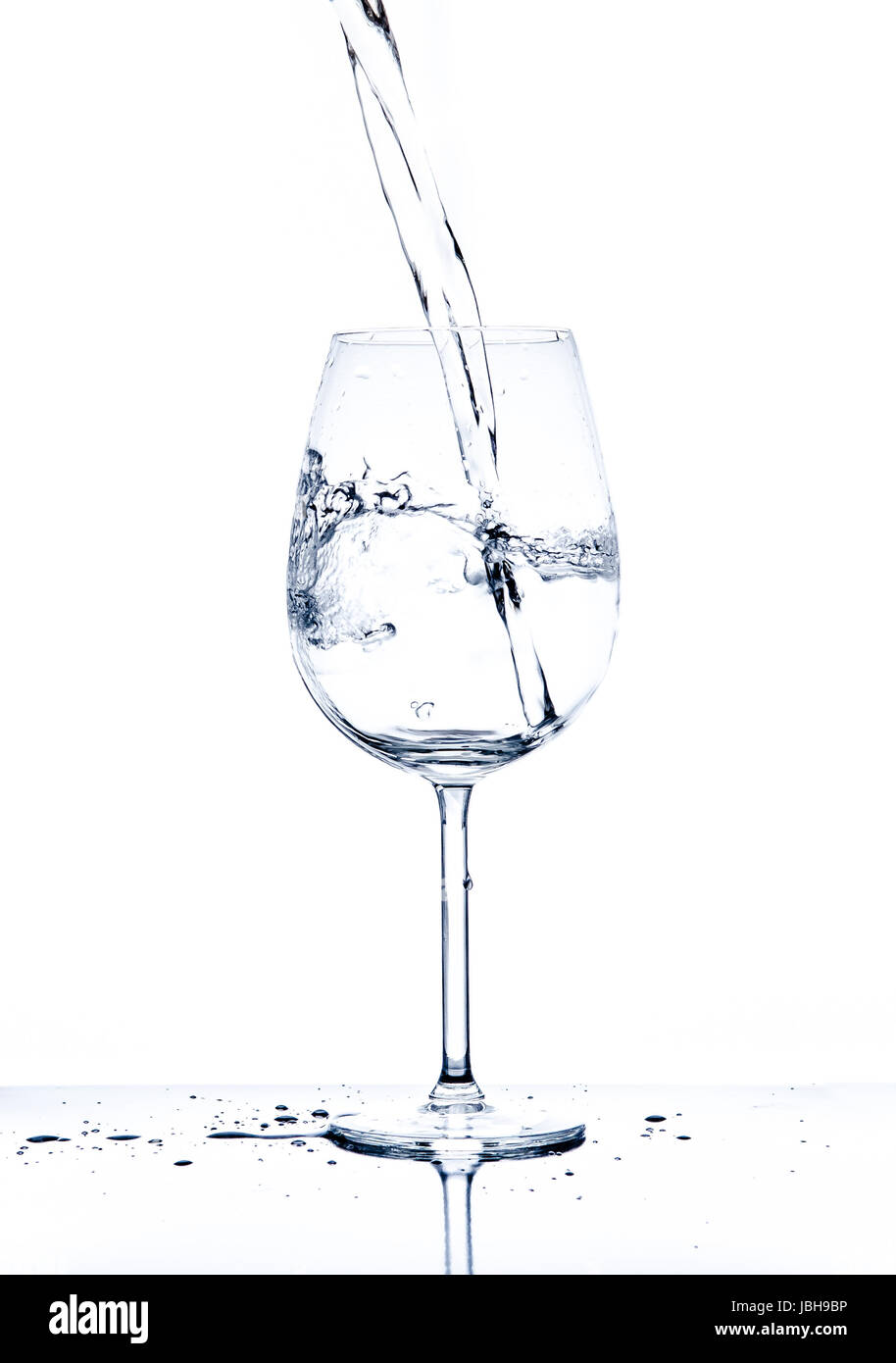 Glass with the stream of dinking water on white background Stock Photo ...
