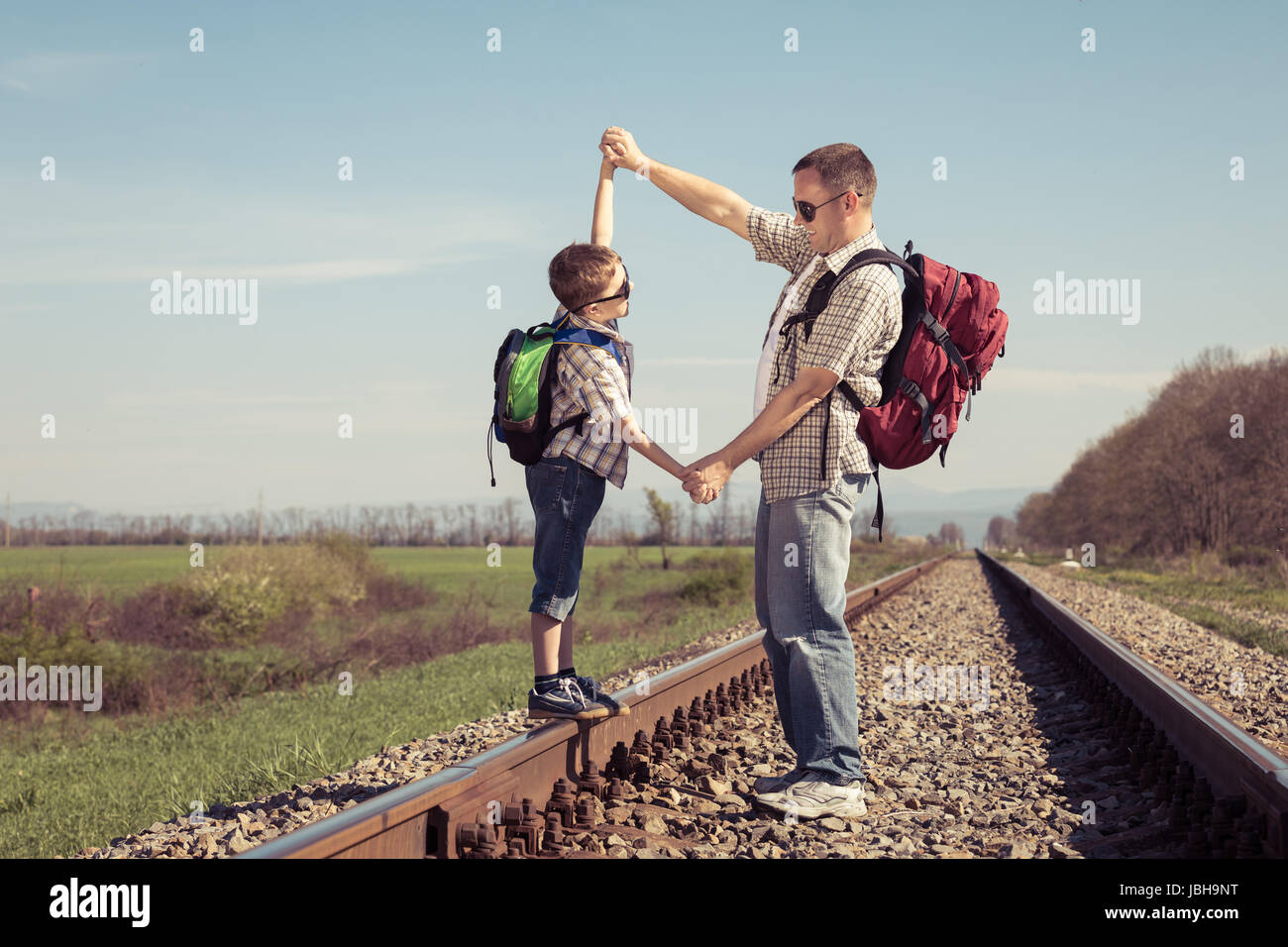 Father and son walking on the railway at the day time. People having ...