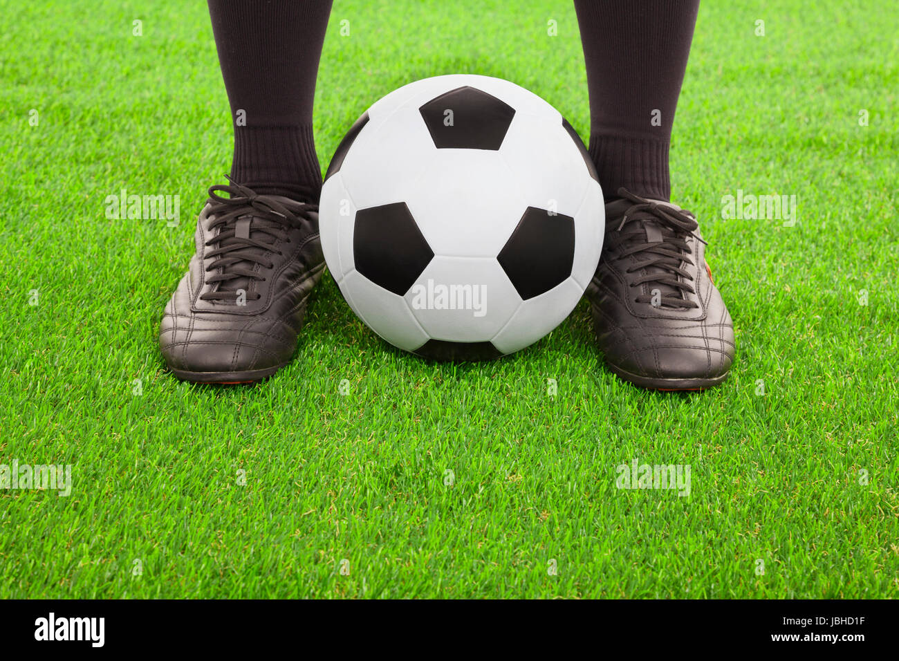 Soccer player's feet with ball on an open playing field Stock Photo - Alamy
