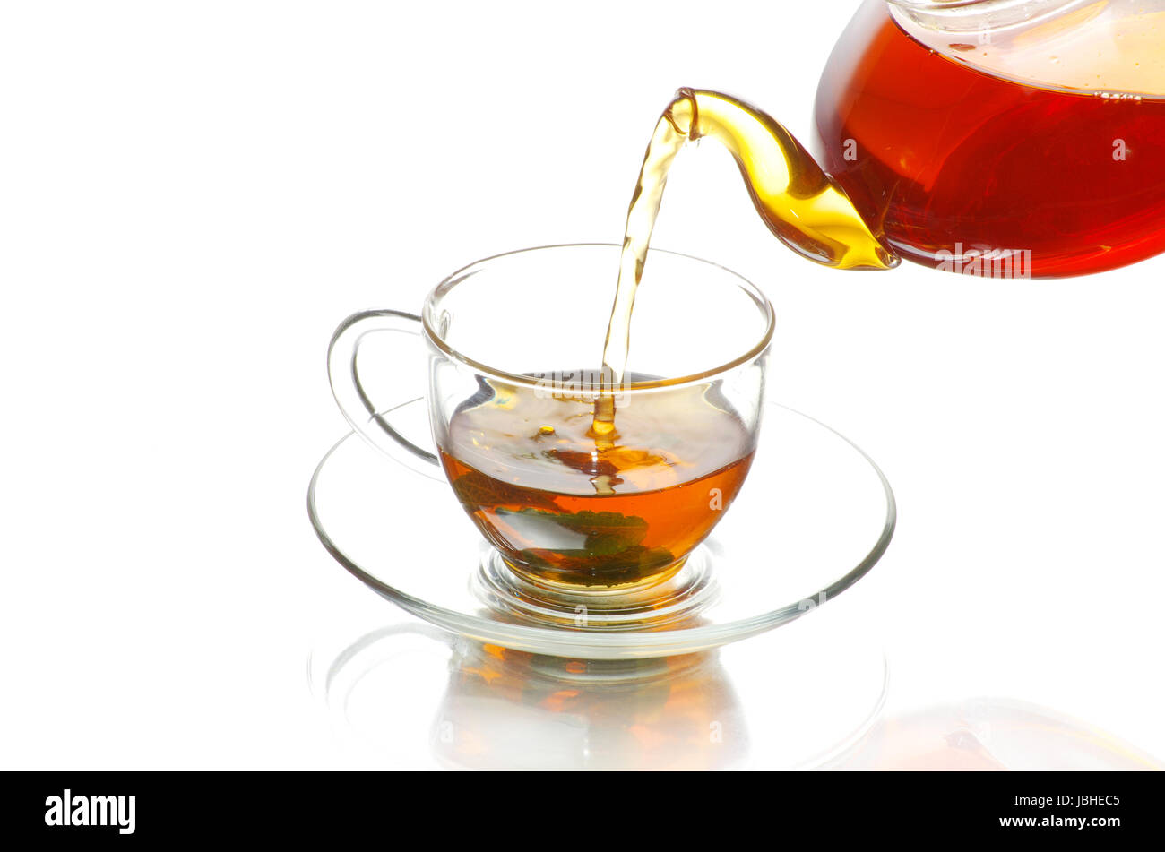Tea being poured into glass tea cup Stock Photo - Alamy