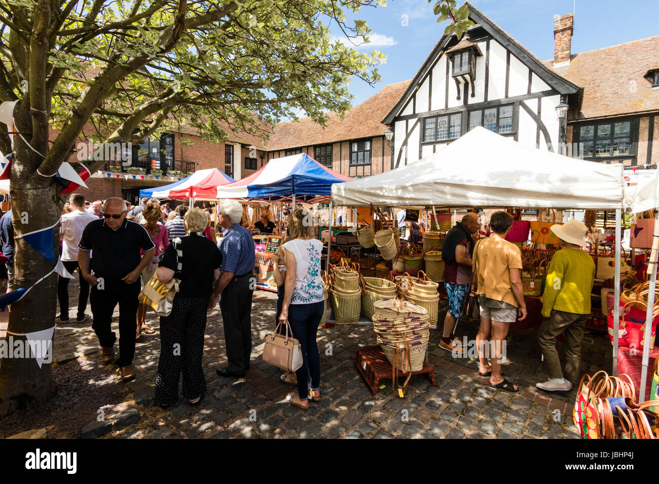 People wandering around busy French market set up at Sandwich town ...