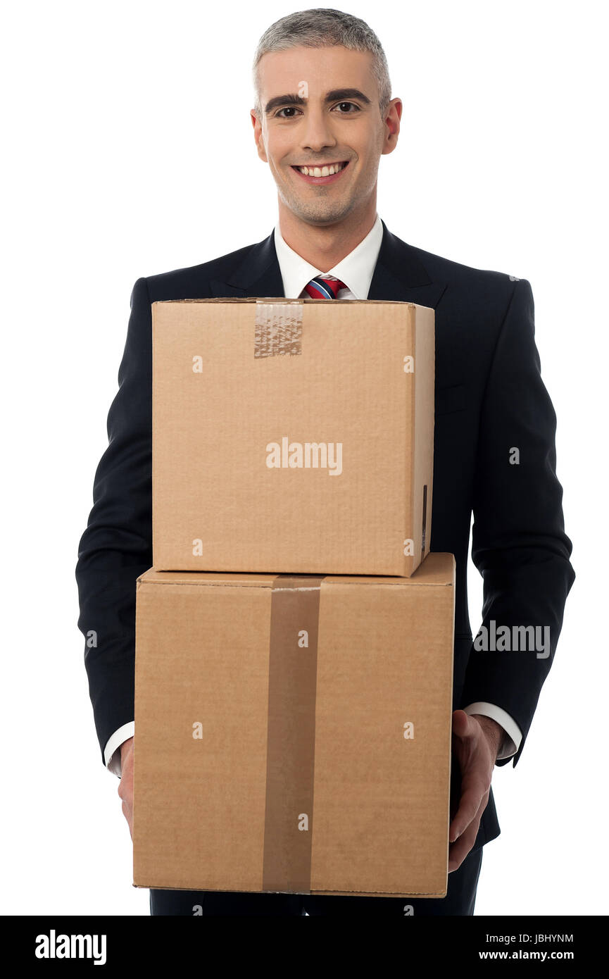 Smiling corporate man holding stack of boxes Stock Photo - Alamy