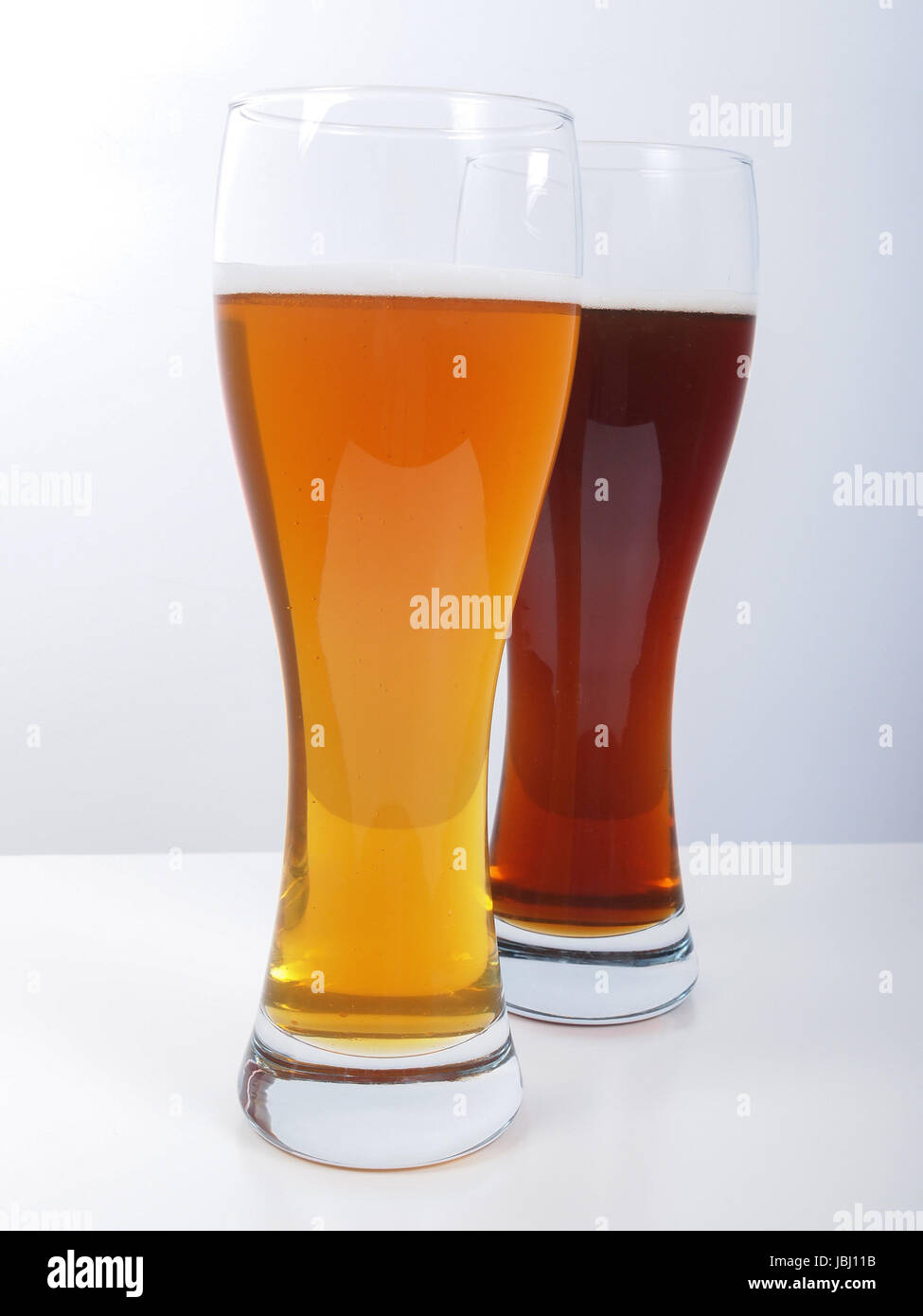 Two glasses of German dark and white weizen beer Stock Photo - Alamy