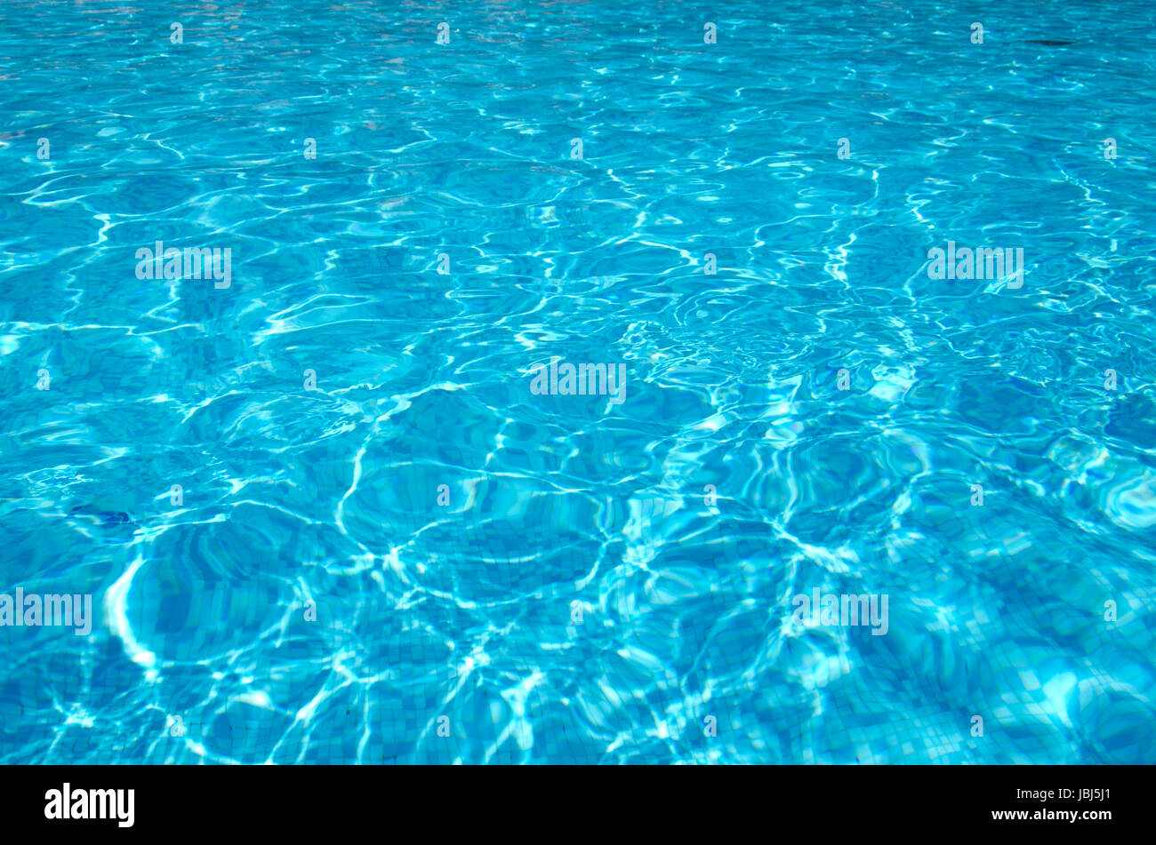 Blue pool water with sun reflections Stock Photo - Alamy