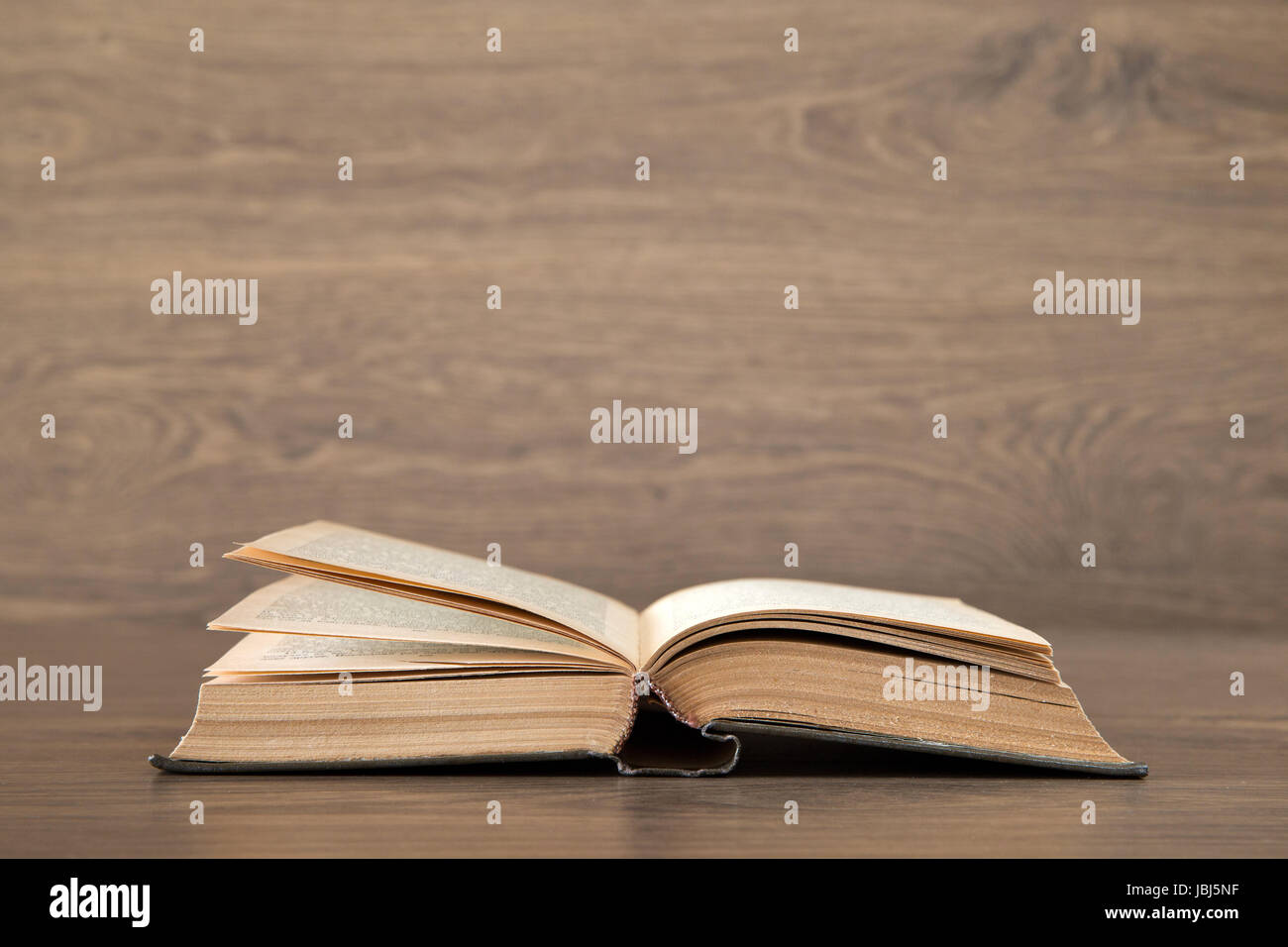 Open book on wood background Stock Photo - Alamy