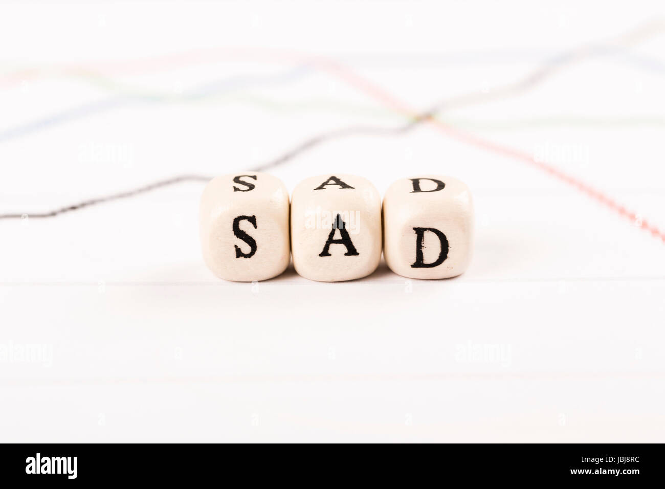 Sad written with wood cubes letters on financial business graph Stock ...