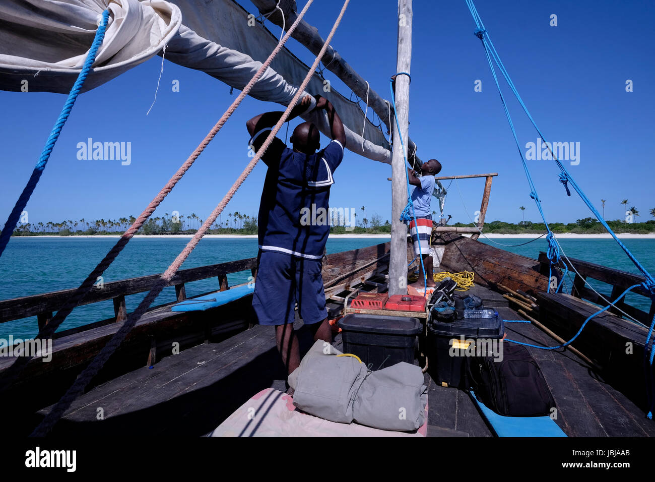 Boat crew trimming sails in a Dhow traditional sailing vessel at the ...