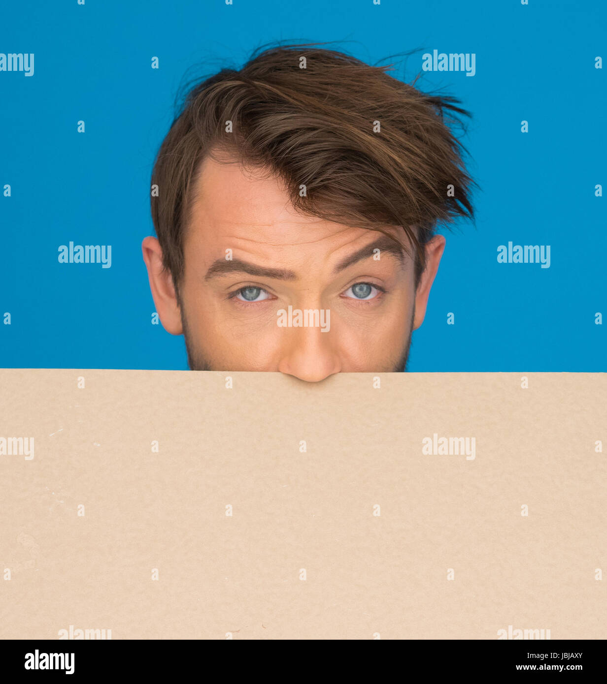 handsome Businessman holding blank poster on blue Stock Photo - Alamy