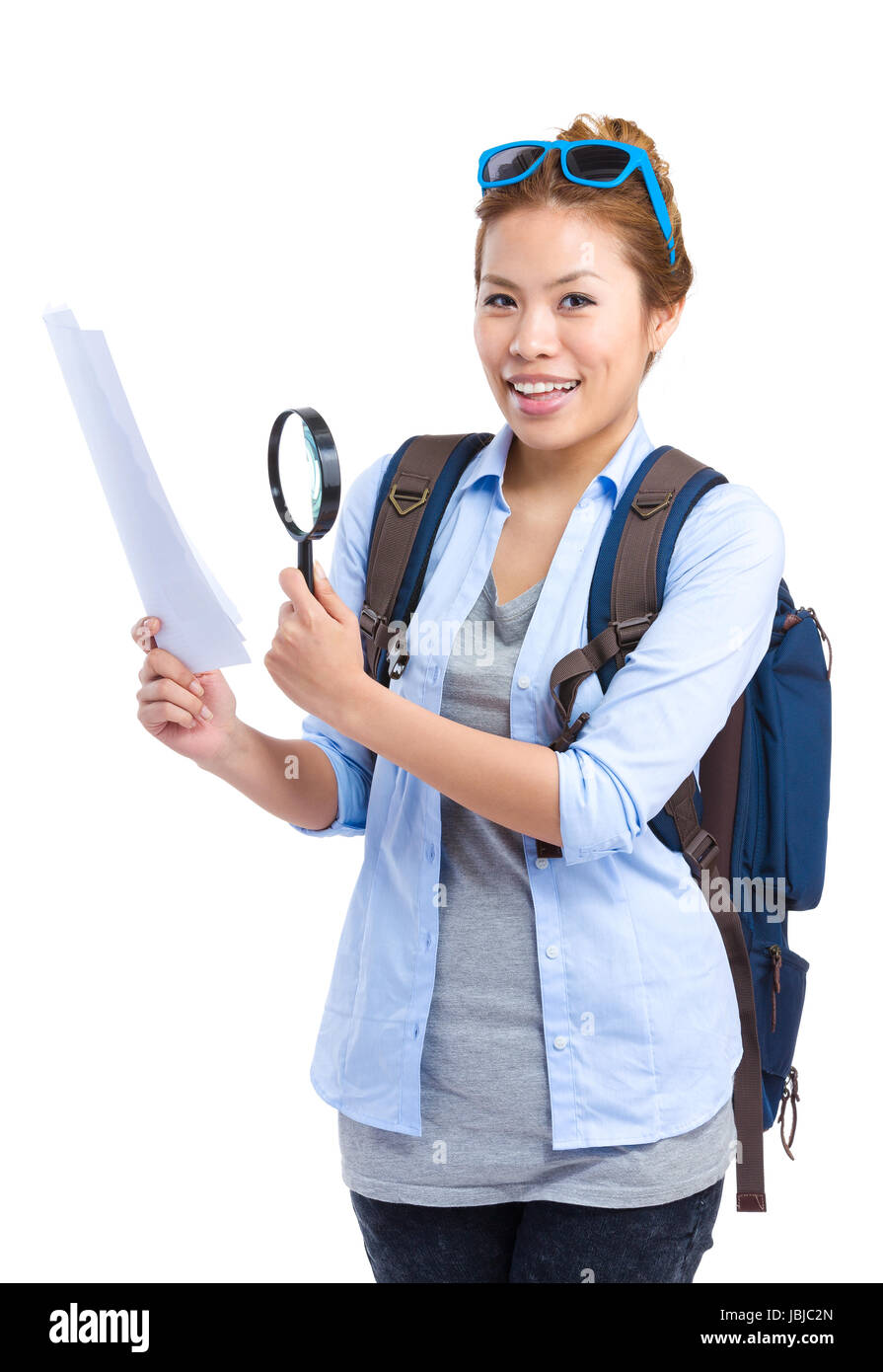 Happy traveler looking at guide with magnify glass Stock Photo - Alamy