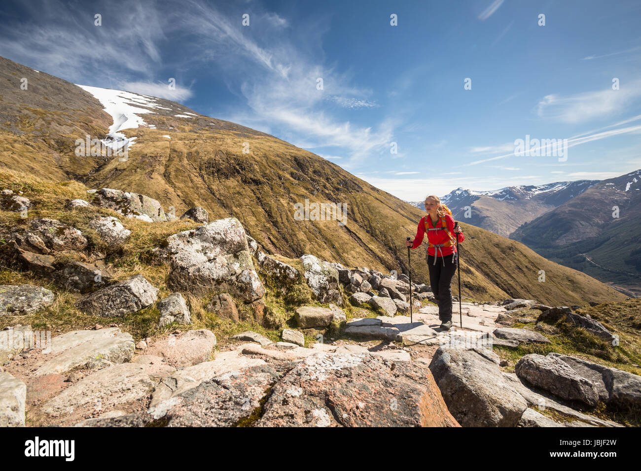 Pretty, young female hiker going uphill Stock Photo - Alamy