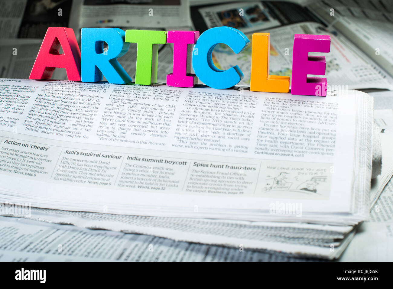 Word article on newspaper. Wooden letters Stock Photo - Alamy
