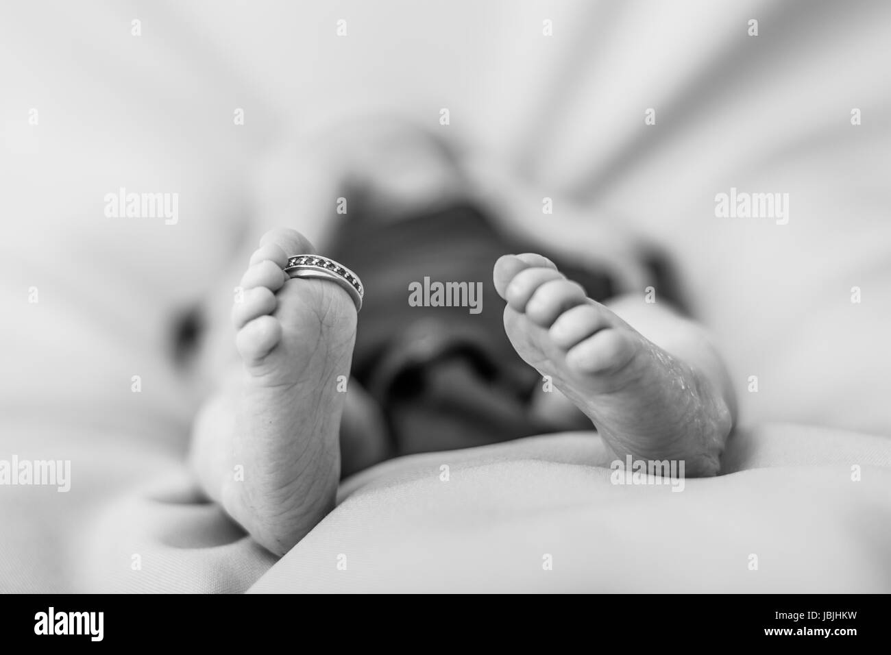 Closeup of newborn feet with a wedding ring Stock Photo - Alamy