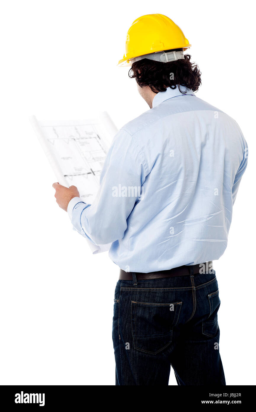 Back view of male engineer reviewing construction site plan Stock Photo ...