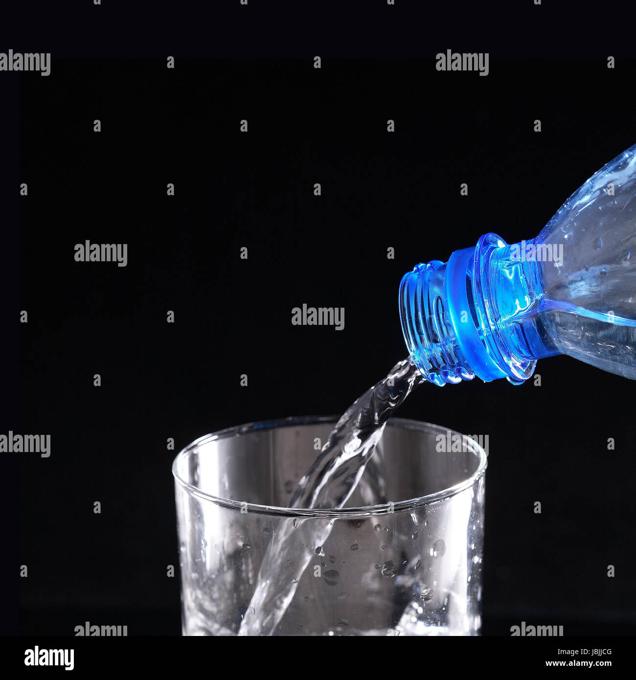 Spilling water on isolated background Stock Photo - Alamy