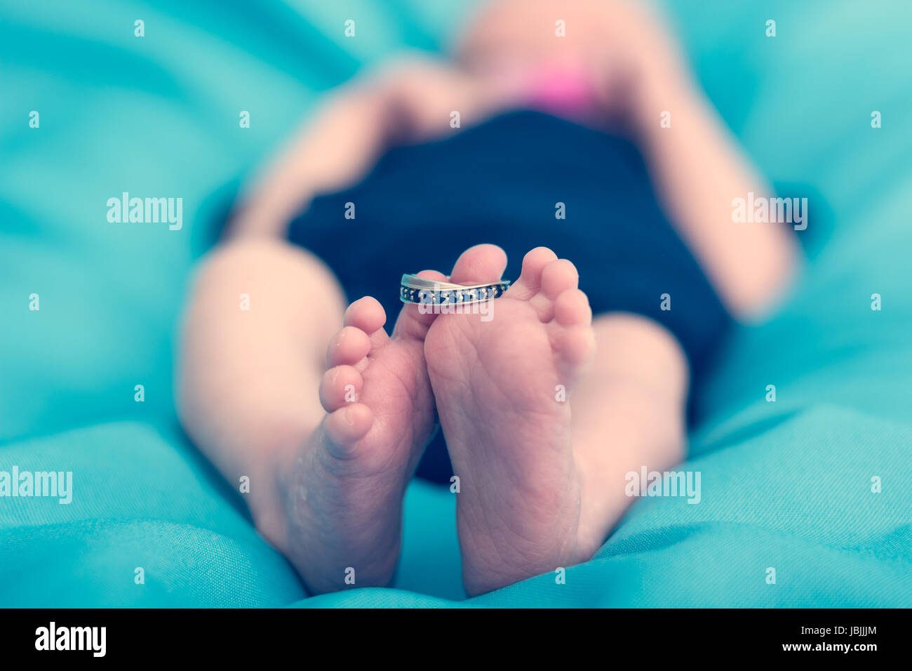 Closeup of newborn feet with a wedding ring Stock Photo - Alamy