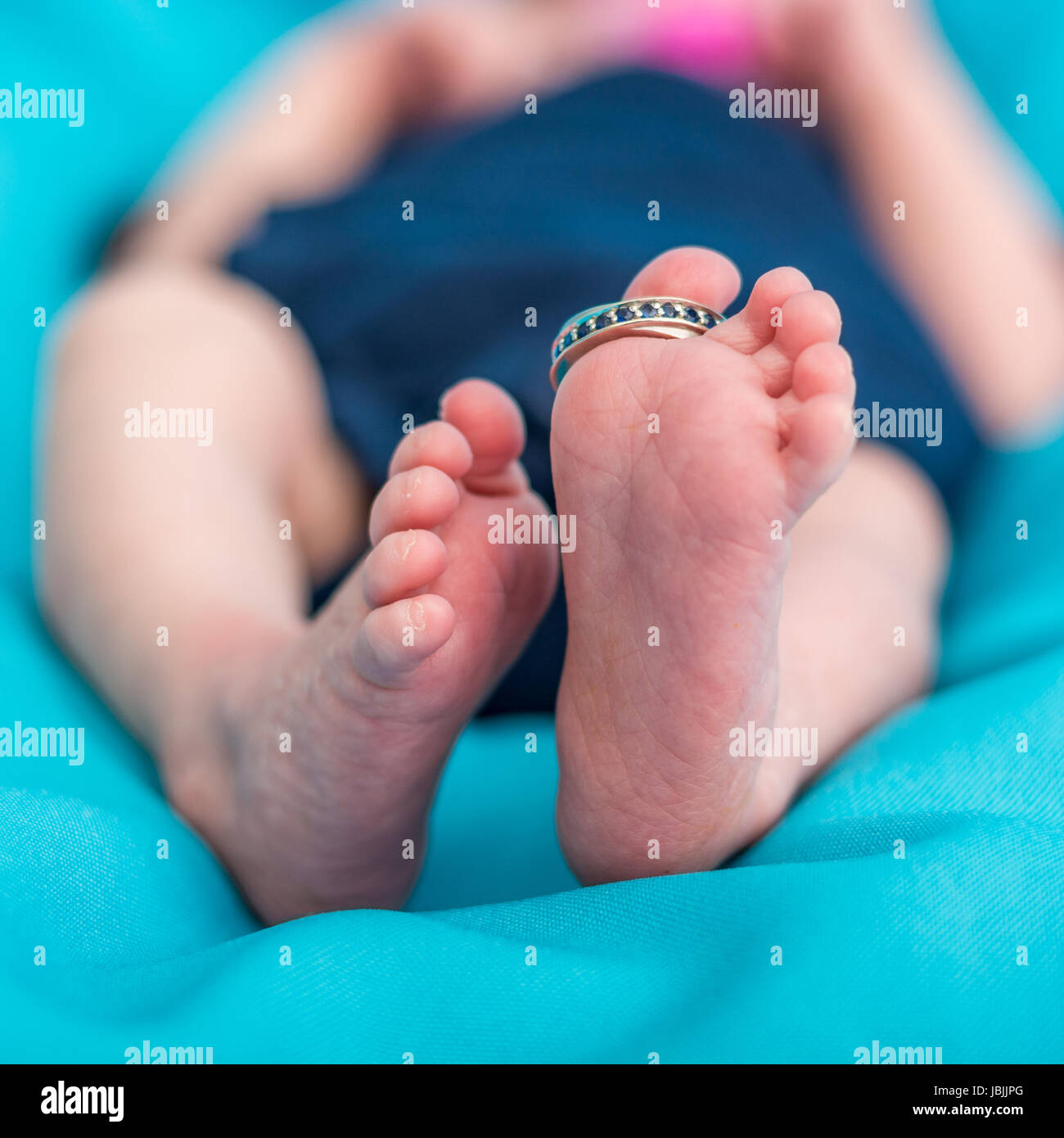 Closeup of newborn feet with a wedding ring Stock Photo - Alamy