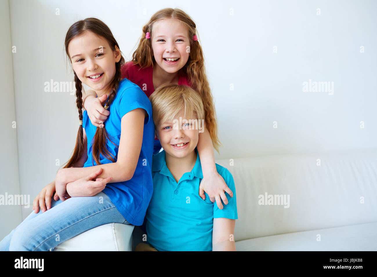 Three affectionate kids looking at camera with smiles Stock Photo - Alamy