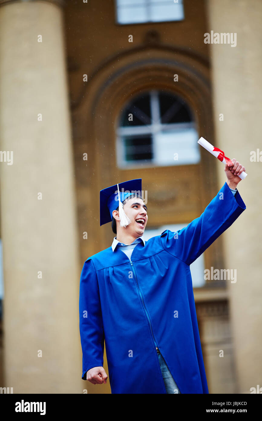 Portrait of confident student with graduation certificate showing ...
