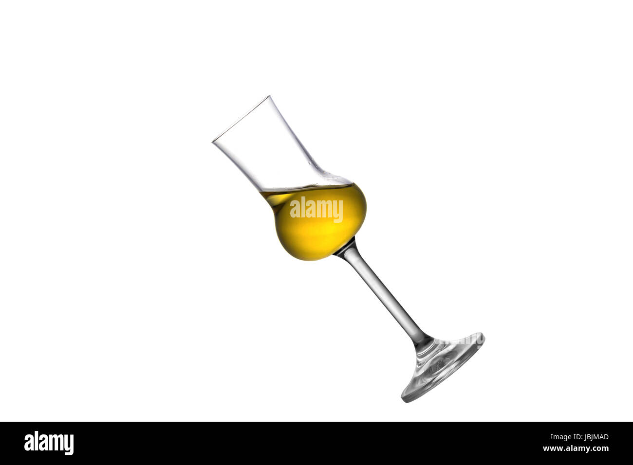 A tilted half full grappa glass isolated on white Stock Photo - Alamy