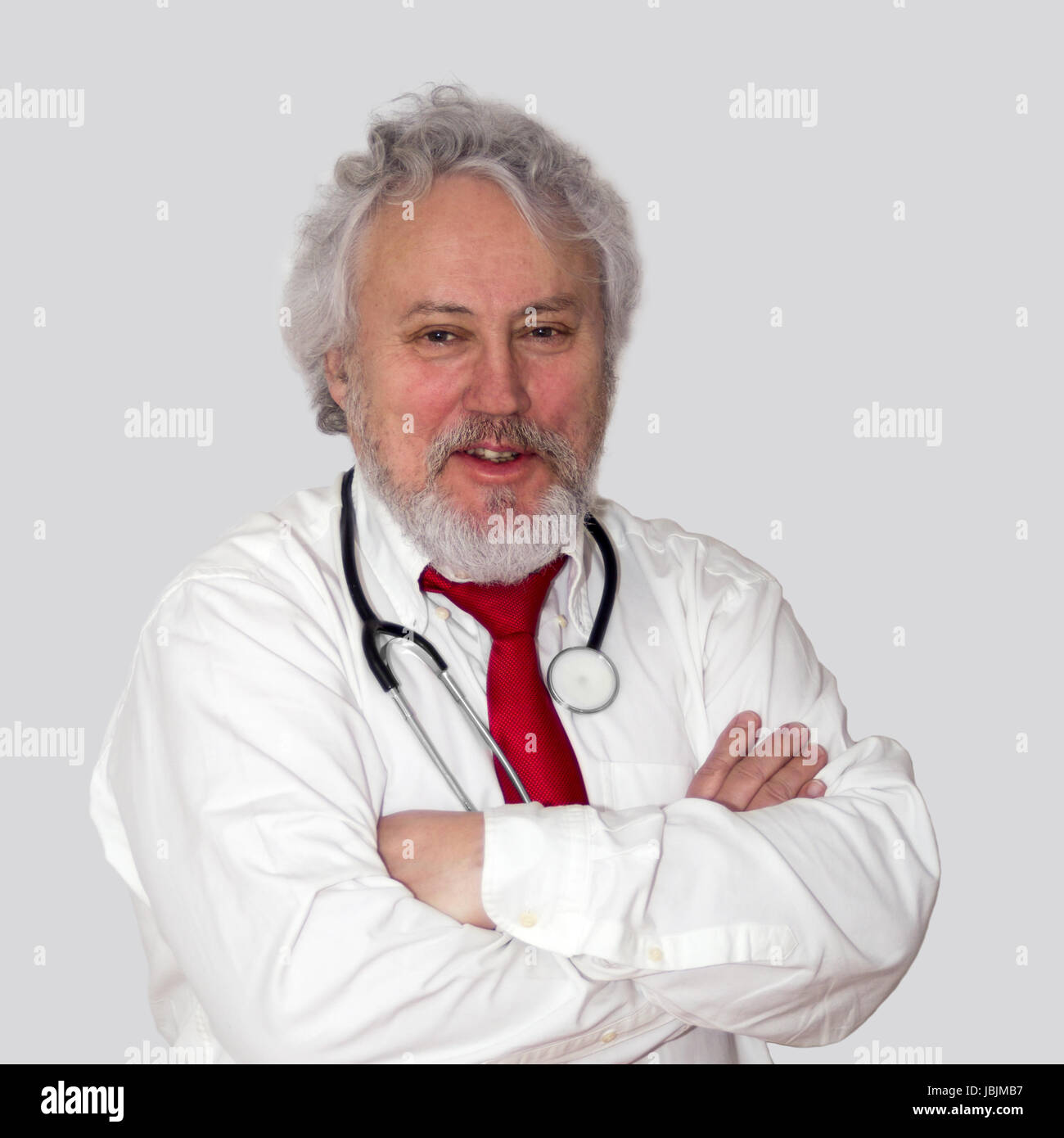 A gray haired and bearded doctor looking friendly Stock Photo - Alamy