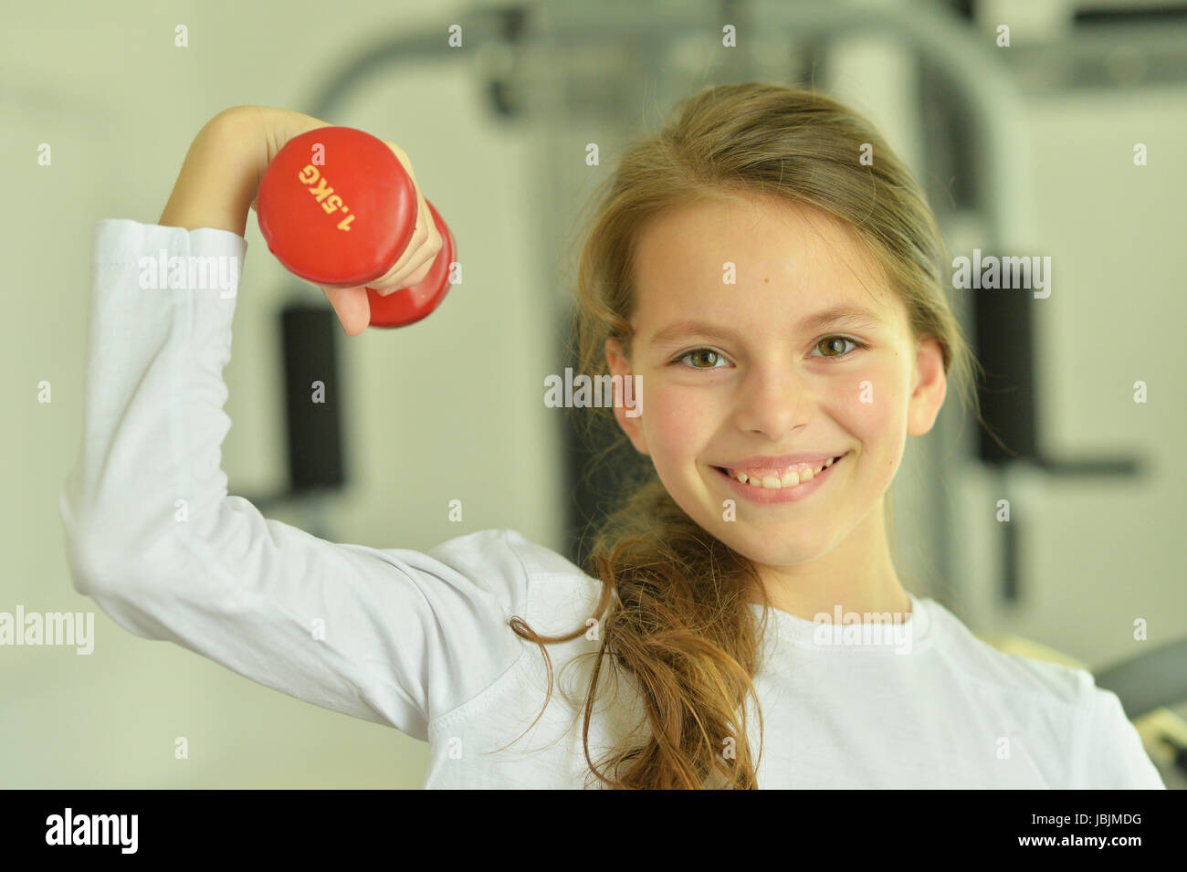 Little girl doing exercises with dumbbell in gym Stock Photo - Alamy