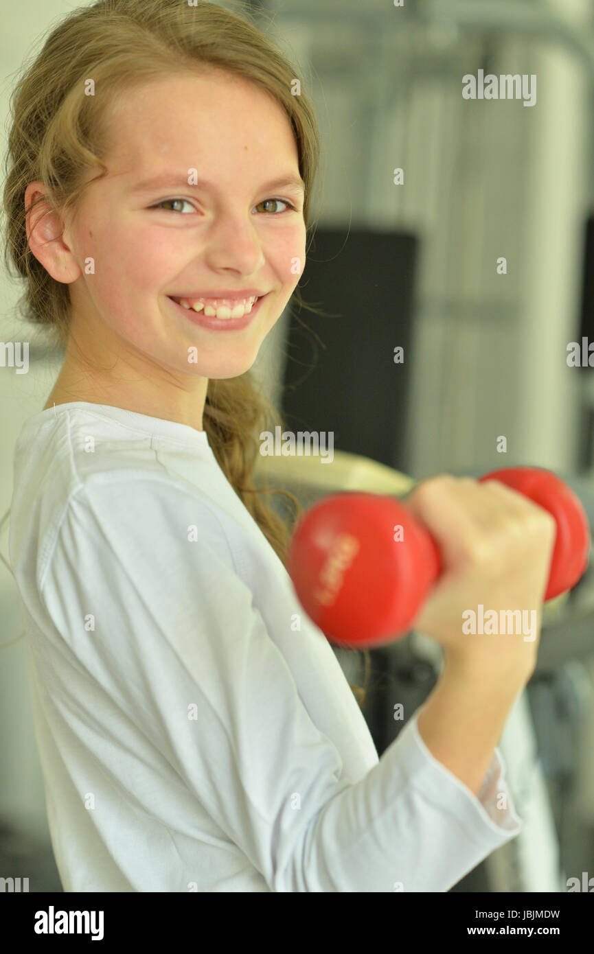 Little girl doing exercises with dumbbell in gym Stock Photo - Alamy