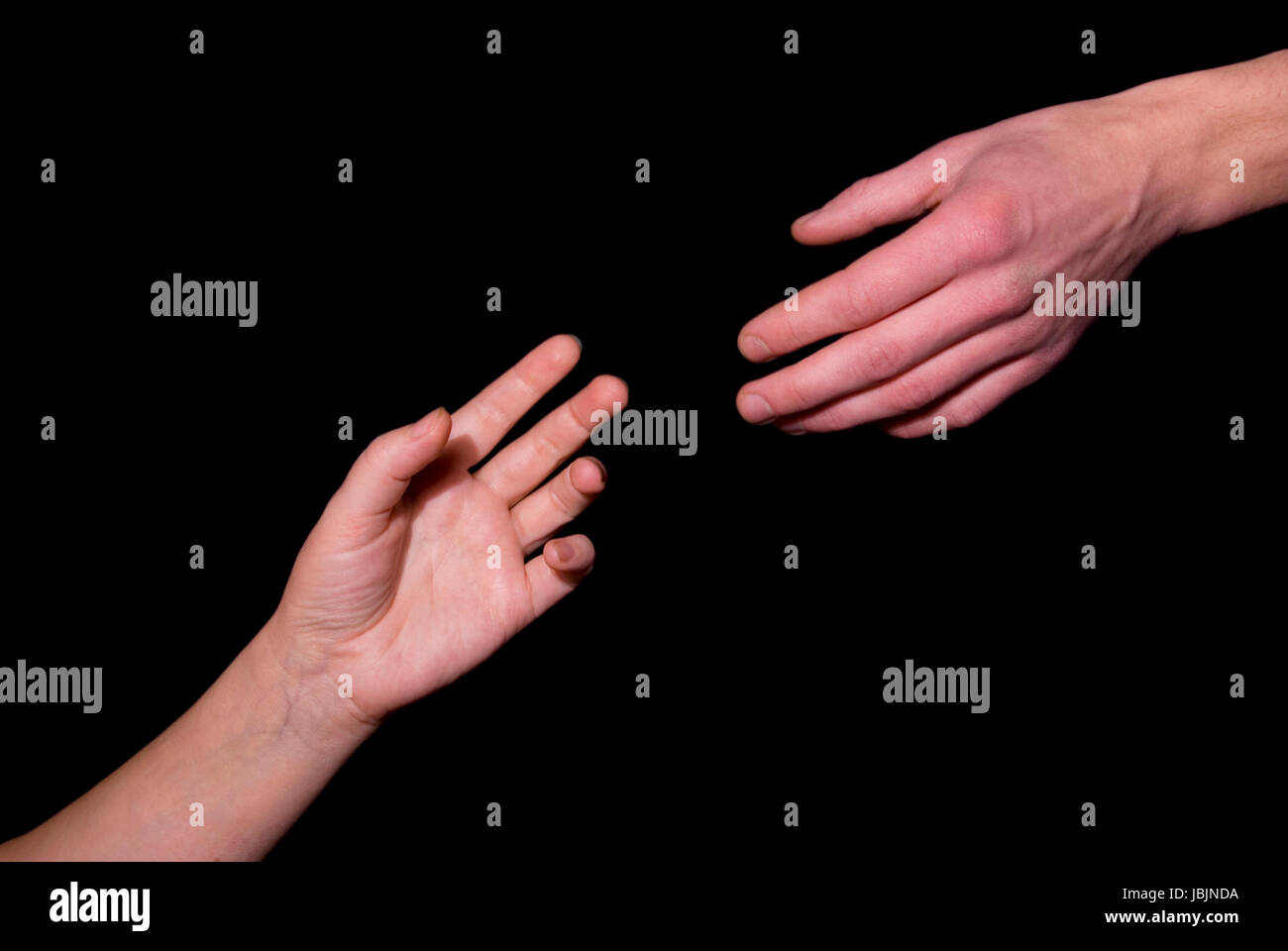 Helping hand on black background Stock Photo - Alamy