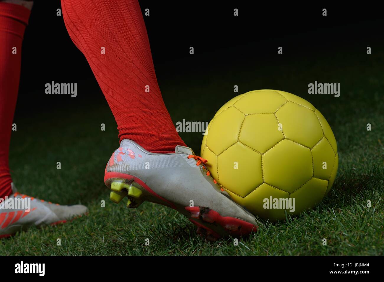 soccer player doing kick with ball on football stadium field isolated ...