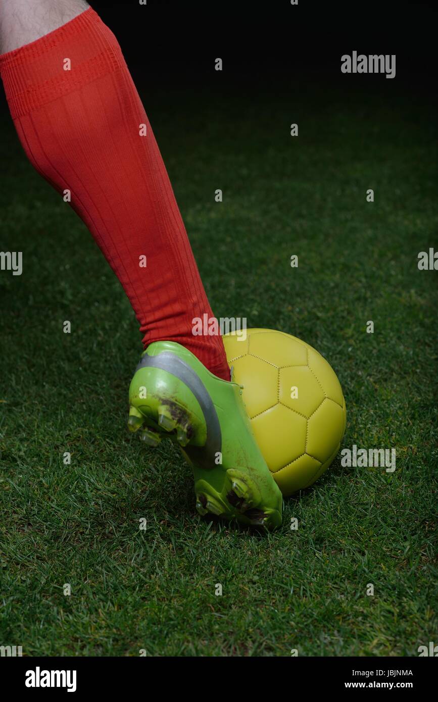 soccer player doing kick with ball on football stadium field isolated ...