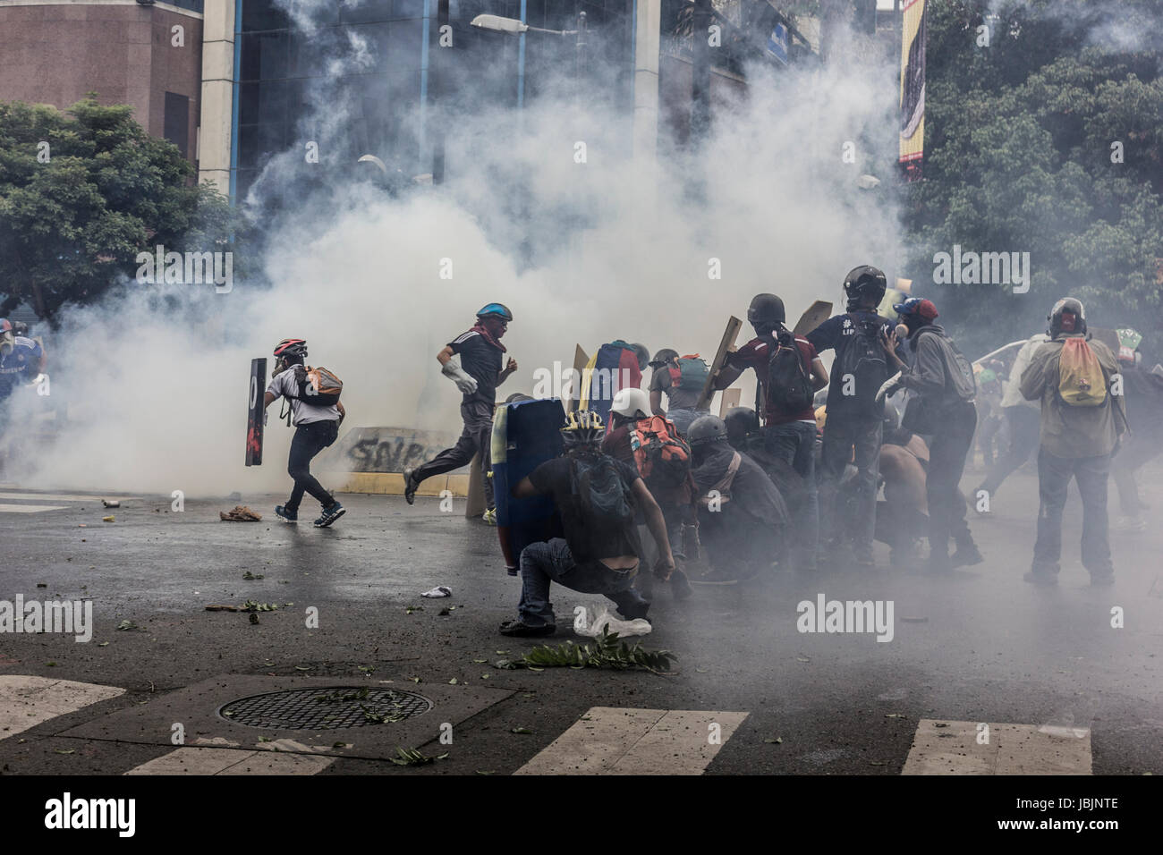Demonstrators protecting themselves from the national police (PNB) with ...