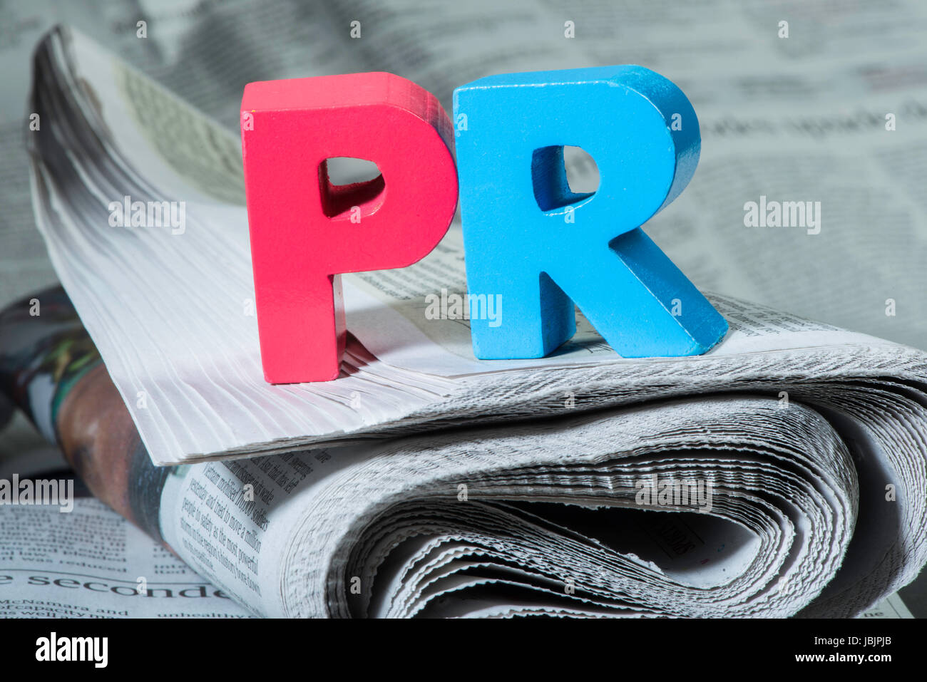 Word PR on newspaper. Wooden letters Stock Photo - Alamy