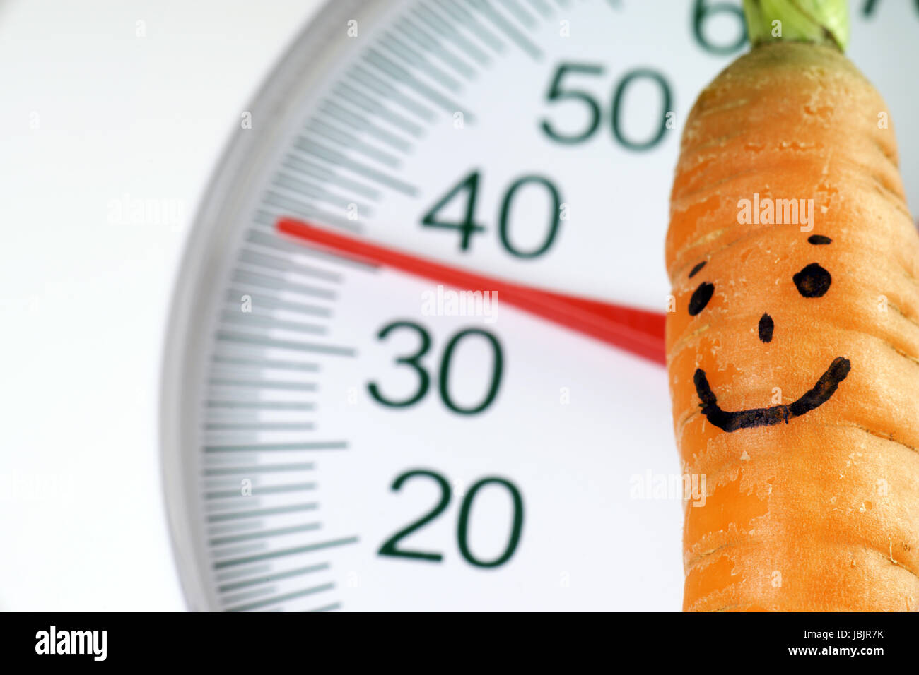 Carrot with face on a Body Scales Stock Photo - Alamy