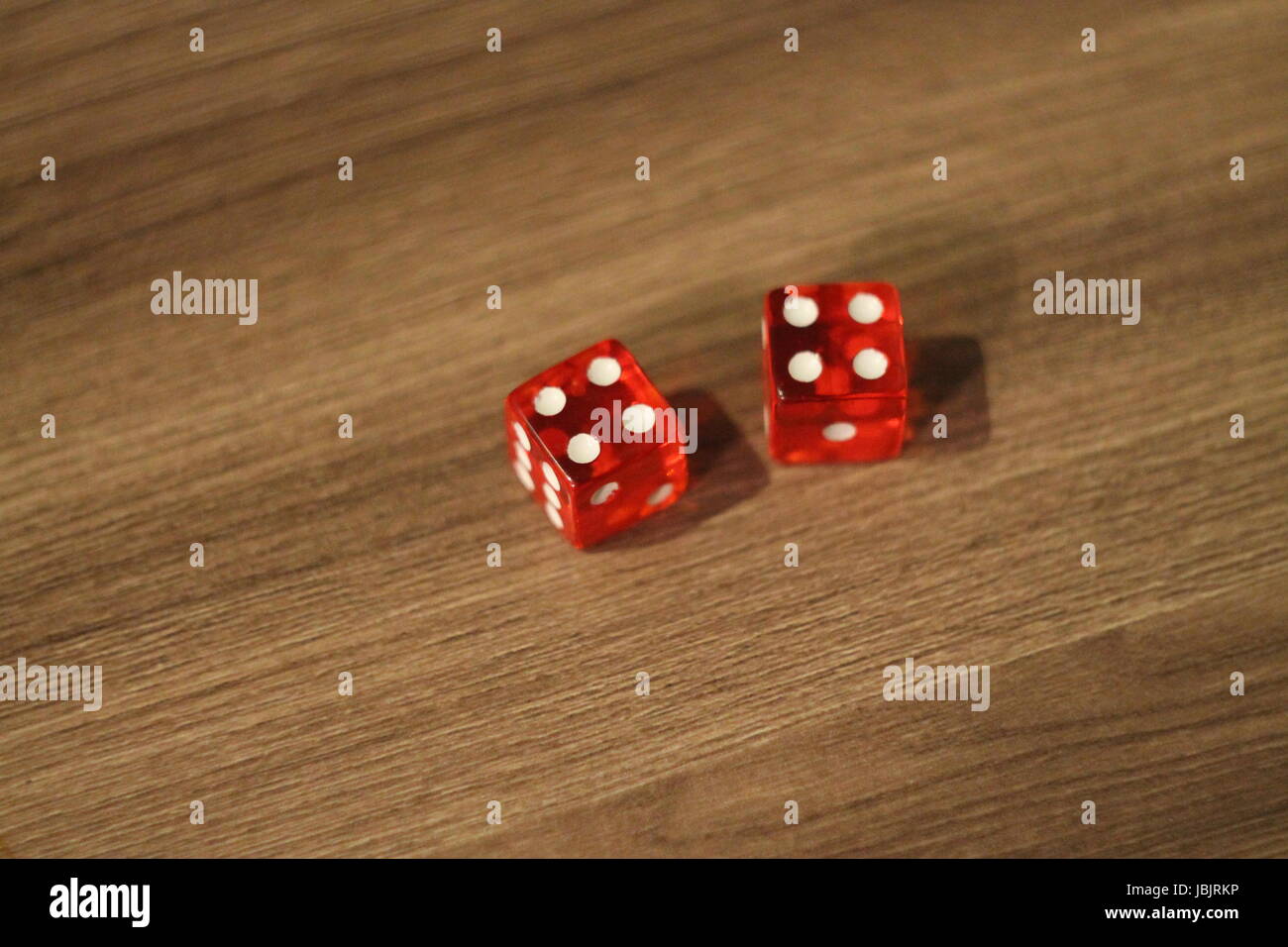 Red dices on wooden texture. brown background Stock Photo - Alamy