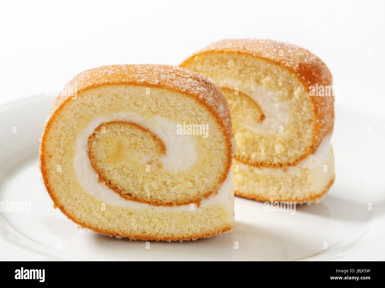 Sponge cake roll with cream filling Stock Photo - Alamy