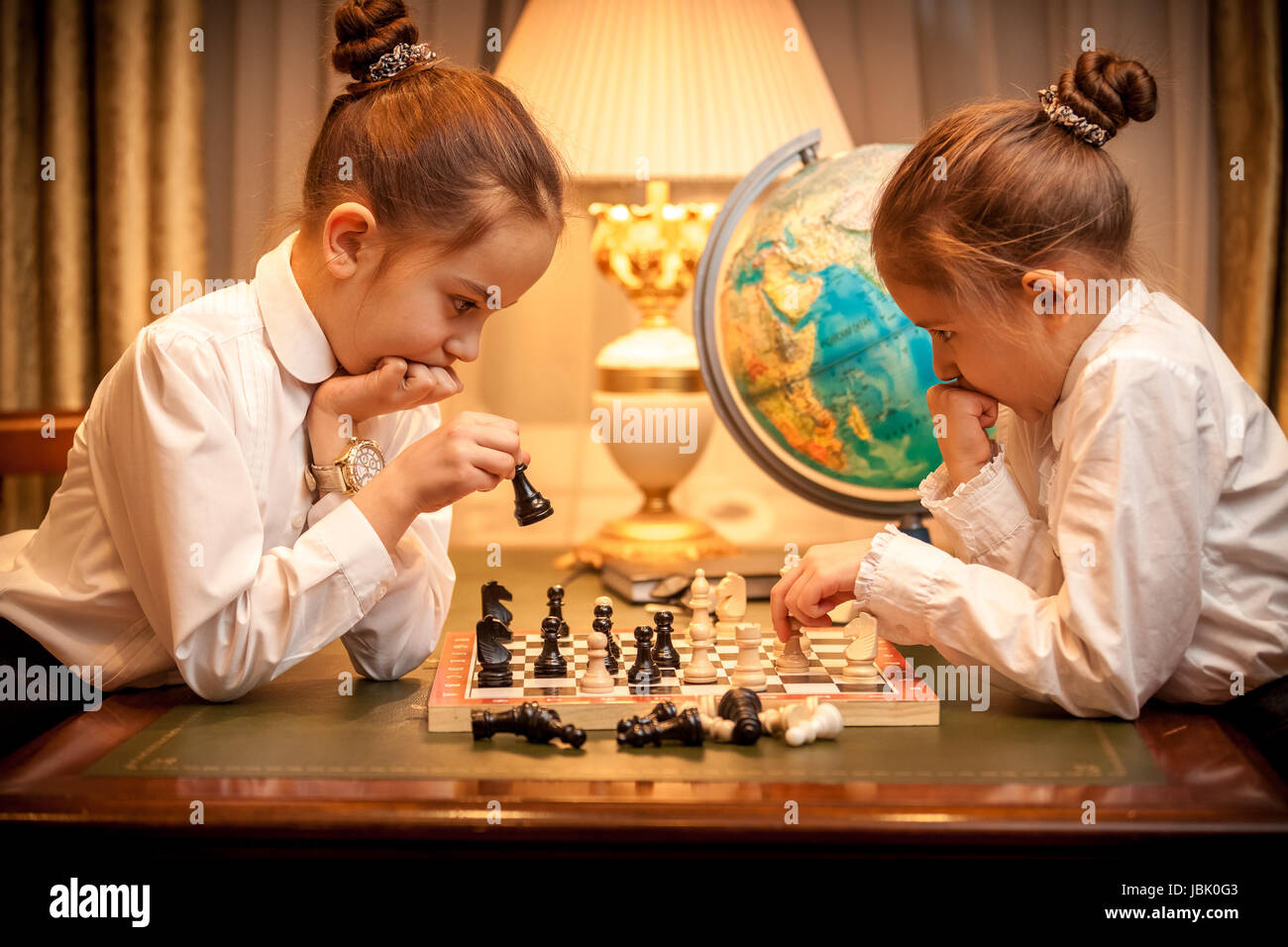 Sisters in school uniform playing chess Stock Photo - Alamy