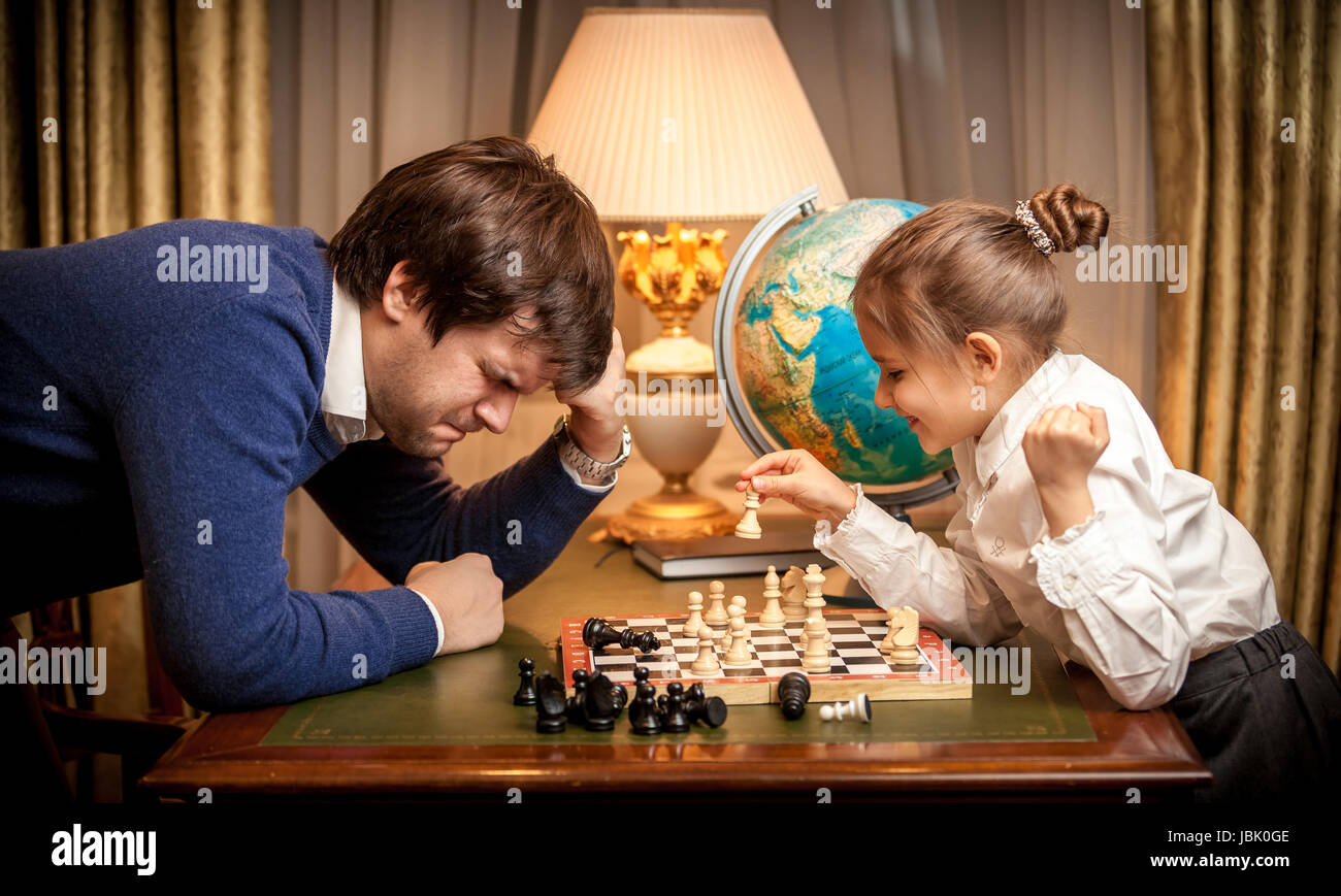 Photo of little girl won chess at man Stock Photo - Alamy